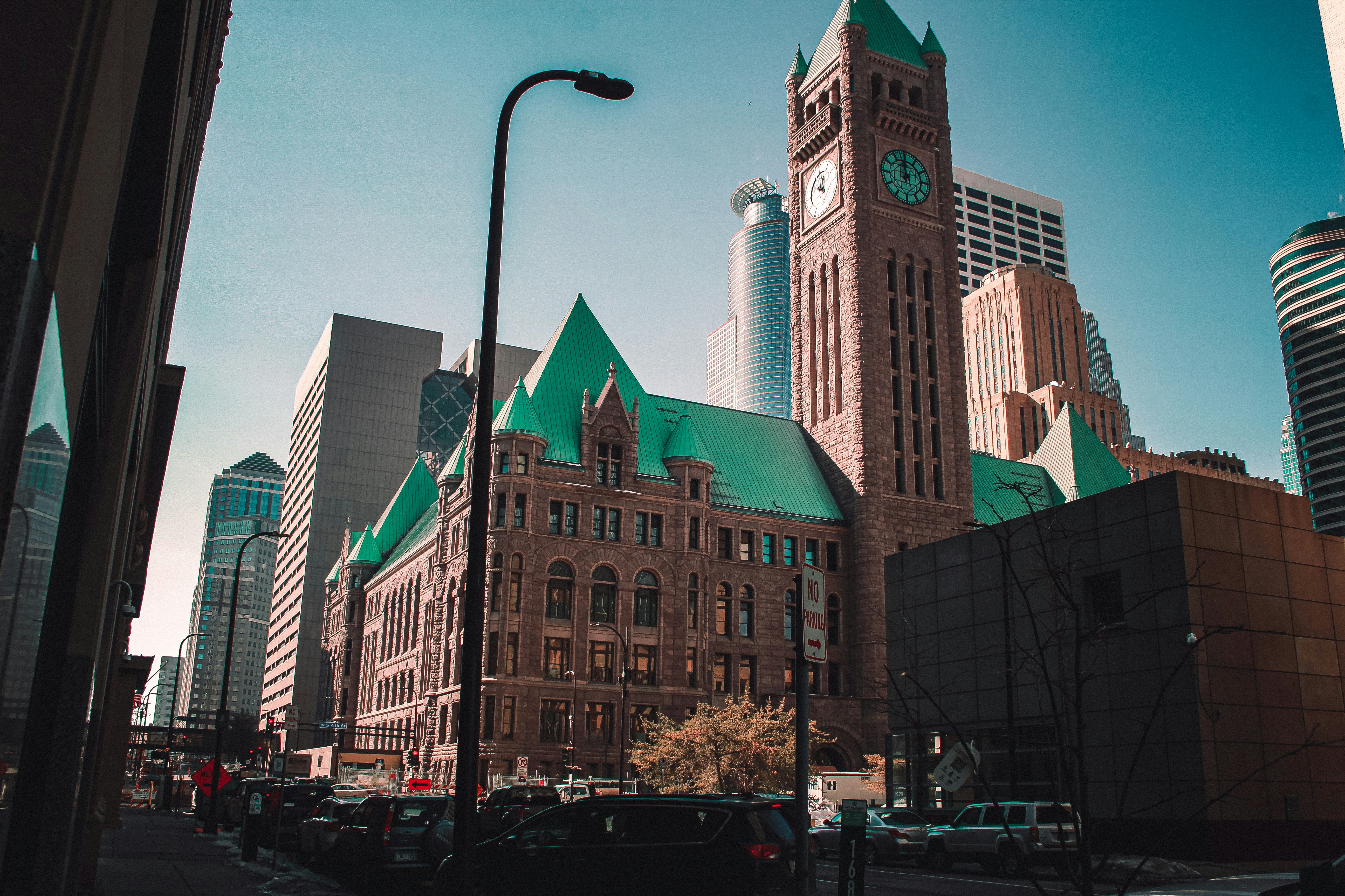 Clock Tower Guardian: A Green-Roofed Historic Facade Framed by a Modern Skyline