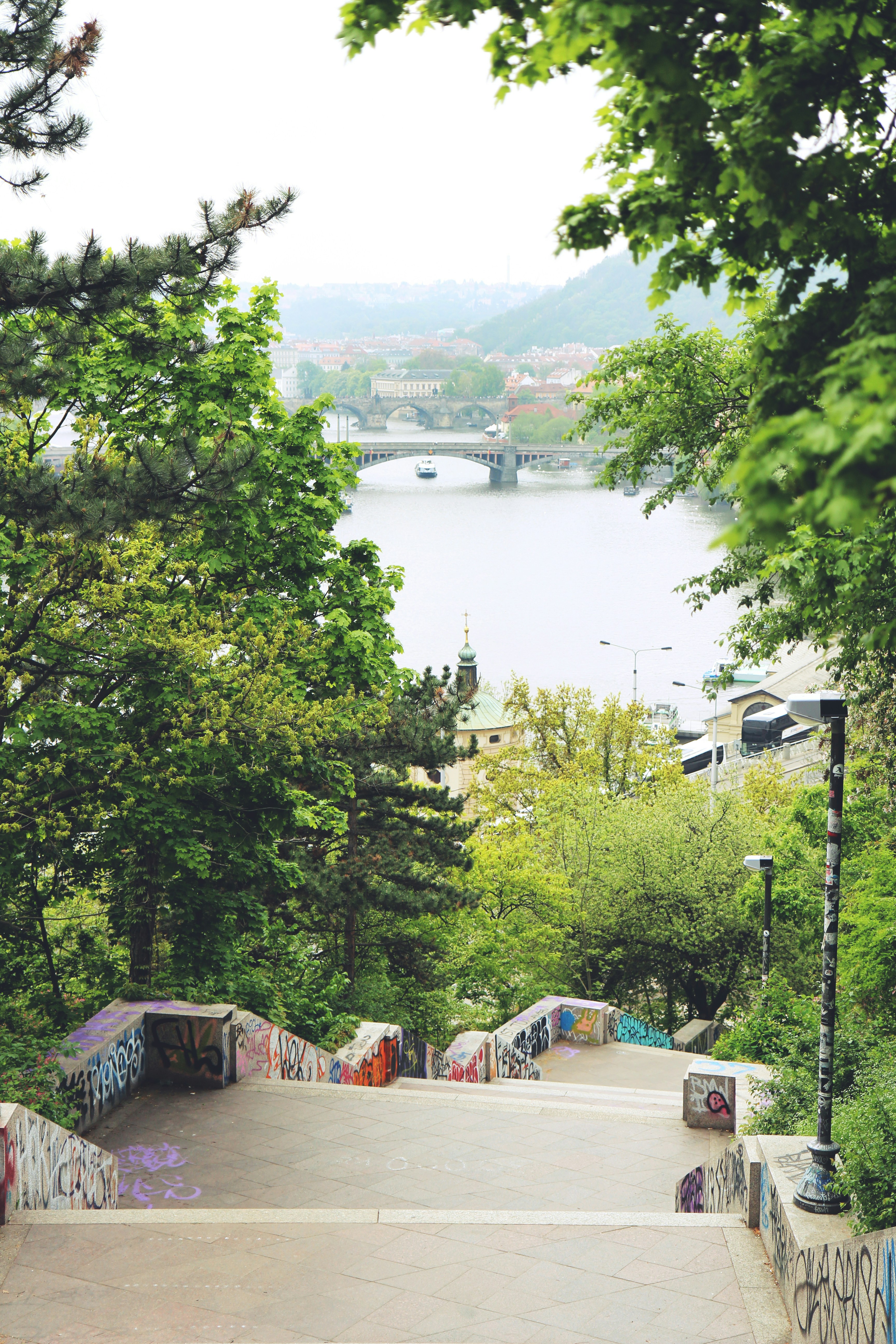 Graffiti Staircase Framing a Quiet Riverside Bridge