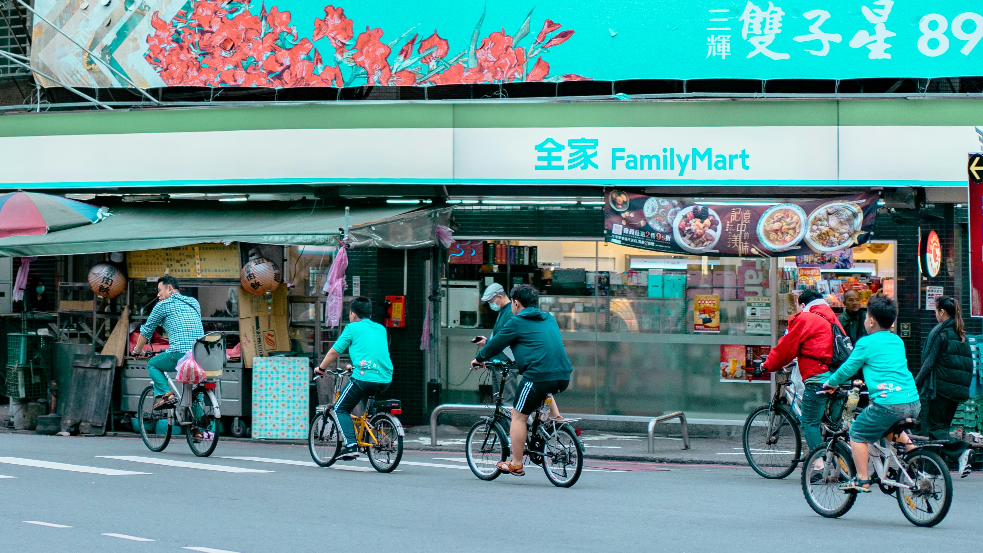 City Cycle Parade in Front of a Neon FamilyMart