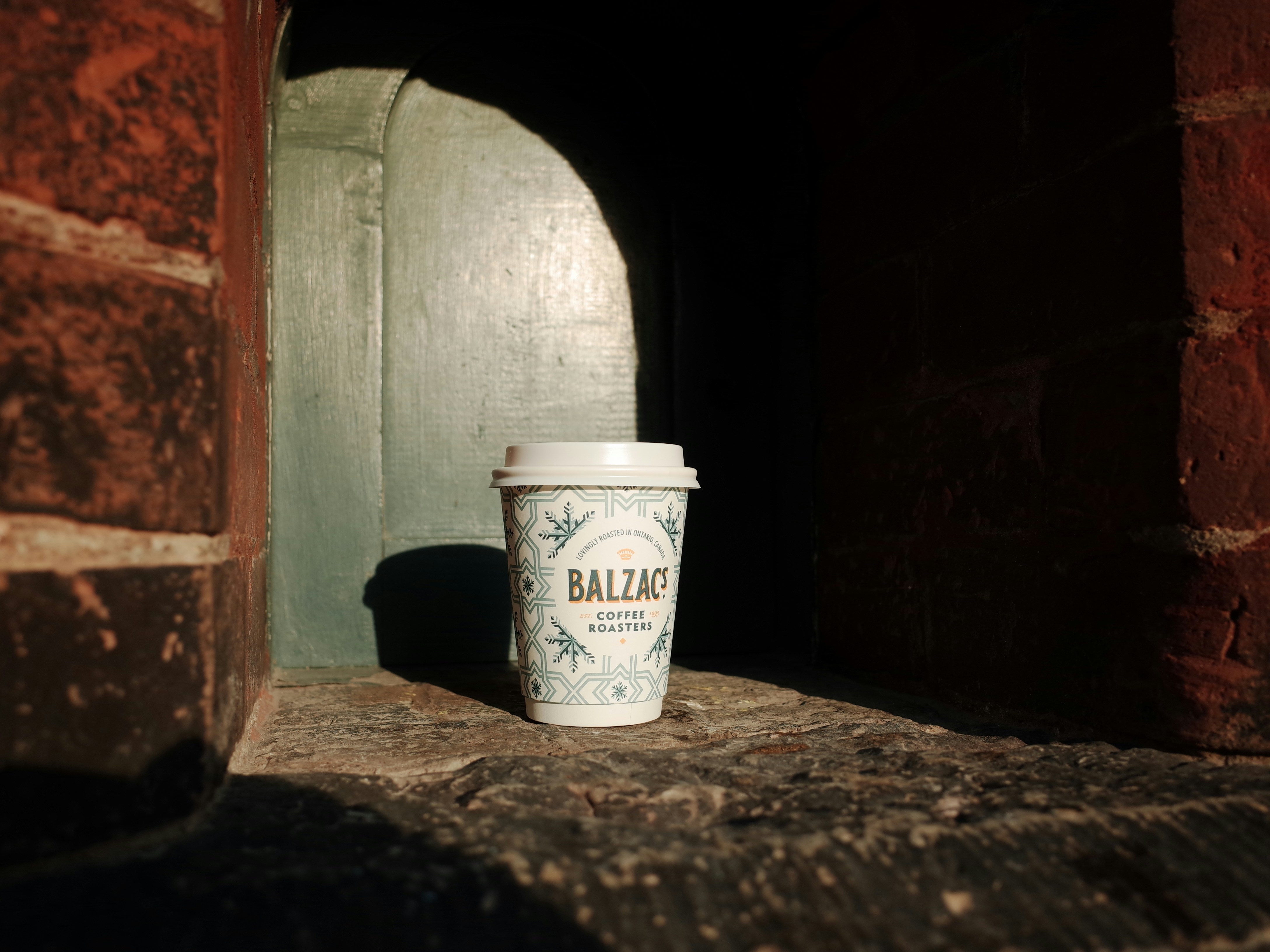 white and blue disposable cup on brown wooden table
