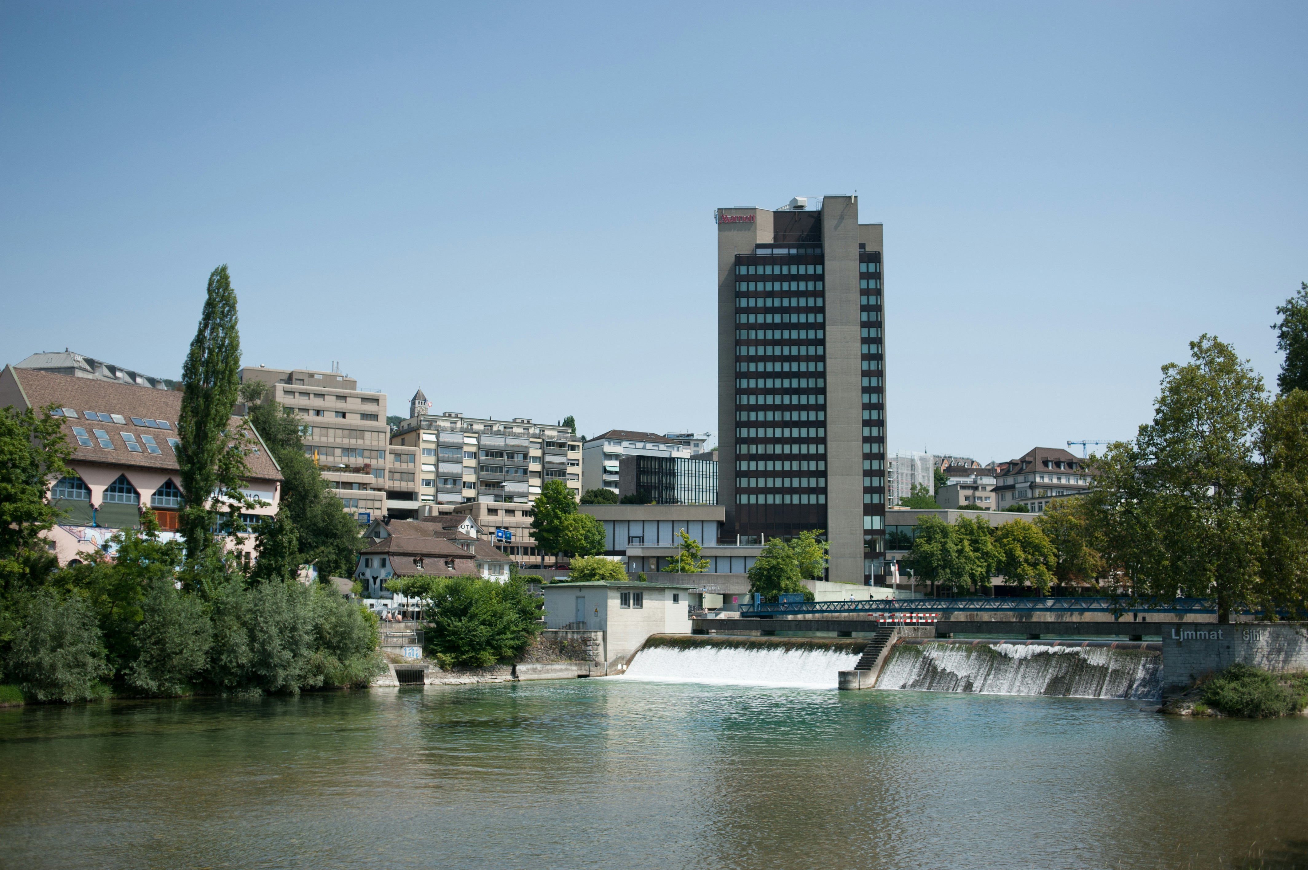 body of water near green trees and buildings during daytime
