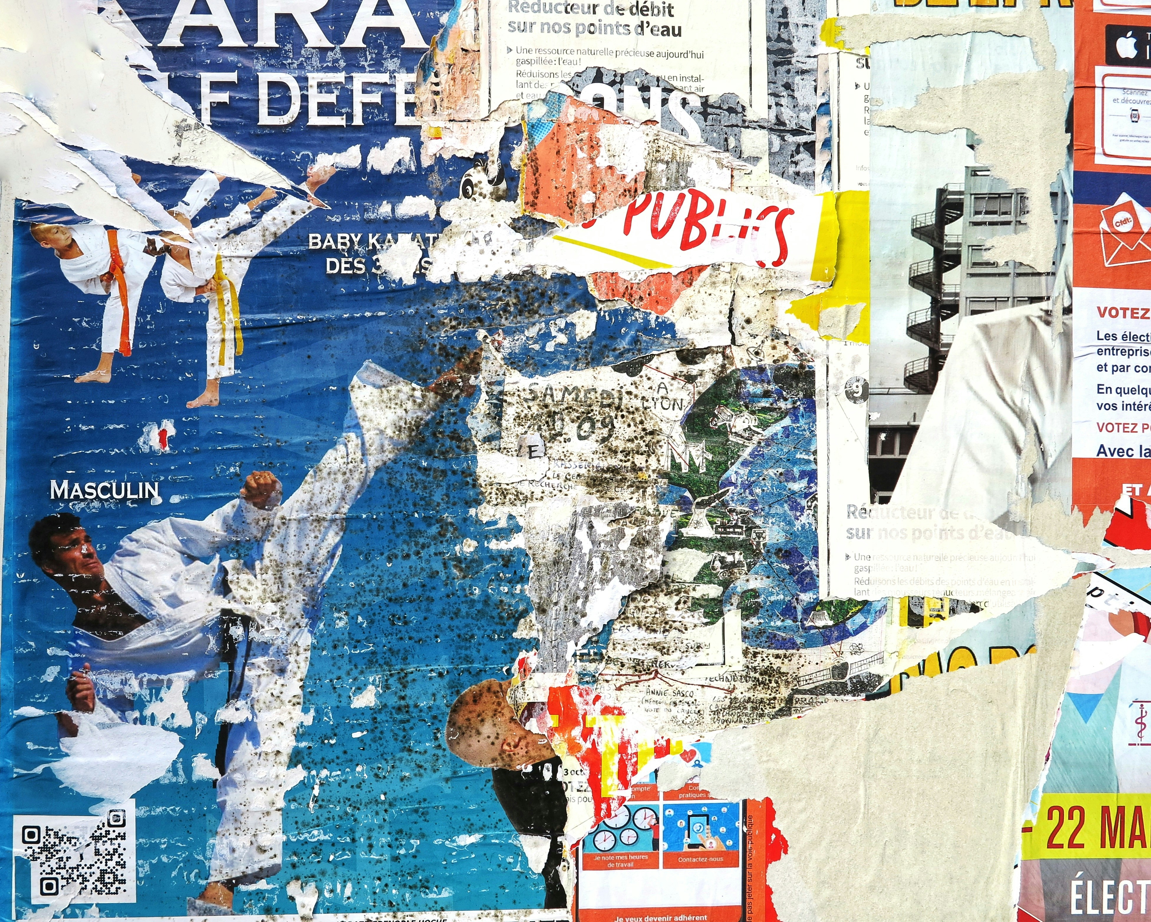 Layered Echoes: Torn Posters Over a Striking Blue Ad