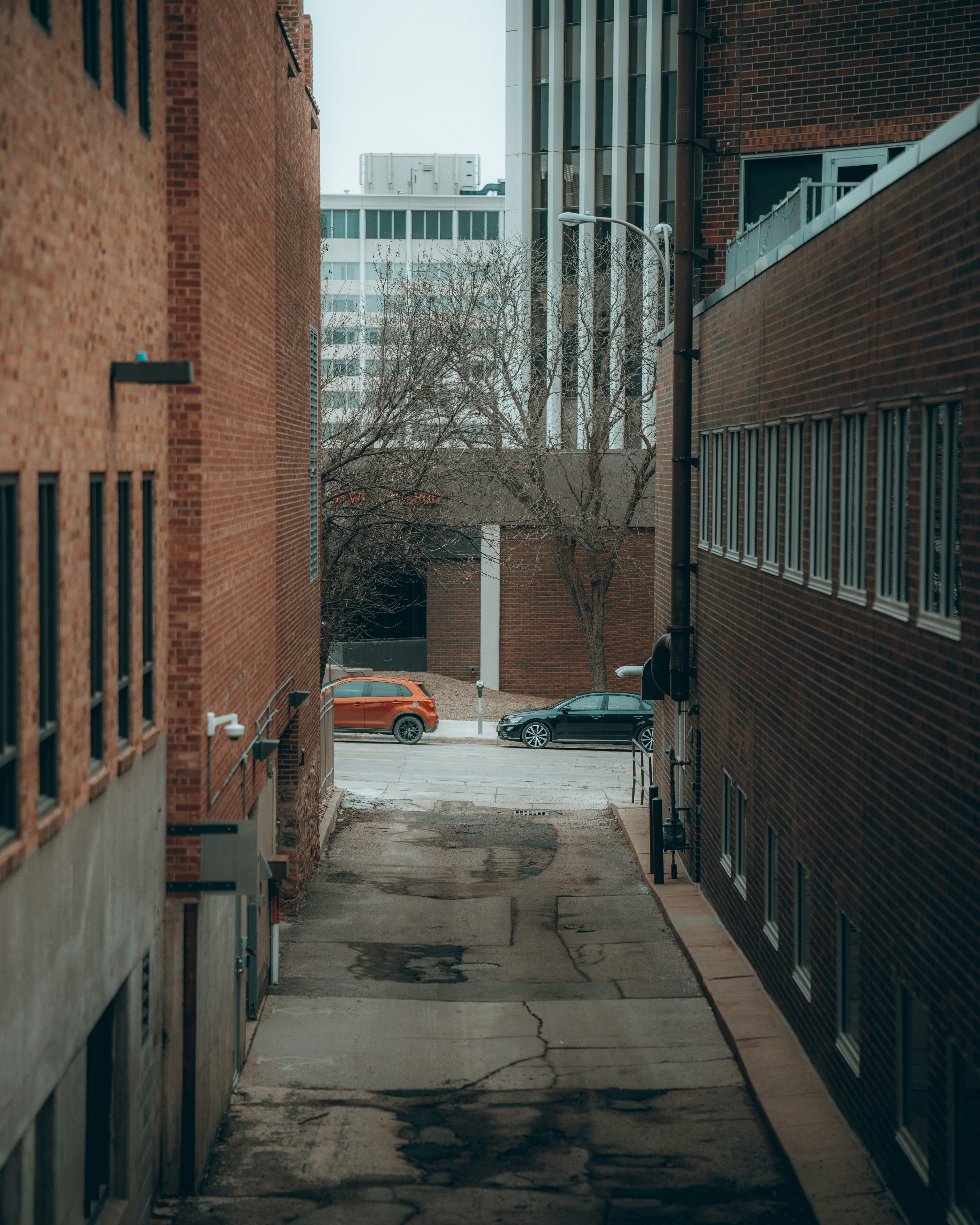 Convergence at the Alley’s End: An Orange Car in a Brick Canyon