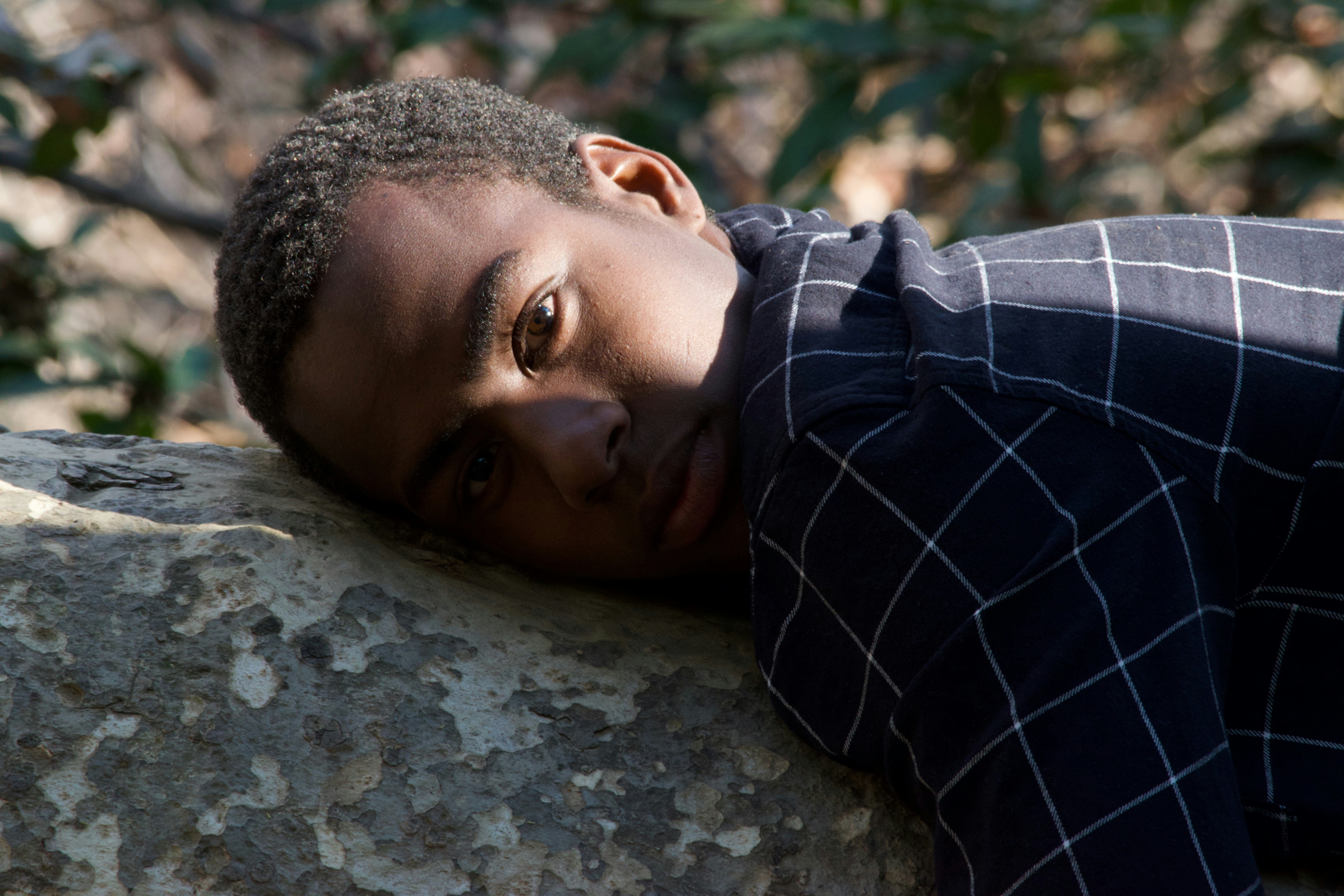 Restful branch  | man in black and white plaid dress shirt lying on gray concrete floor