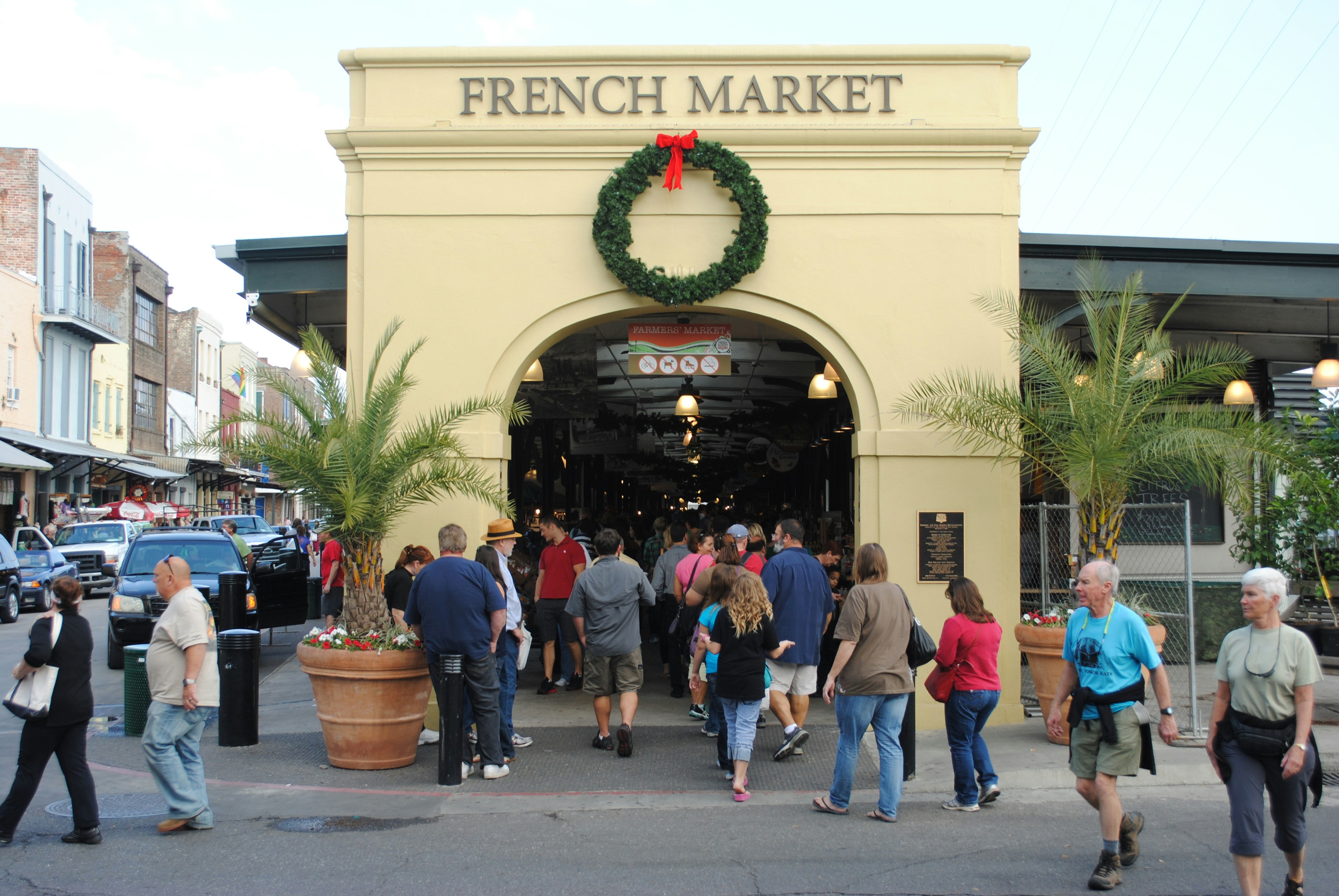 Wreath-Guarded Arch: Crowds at the French Market Entrance