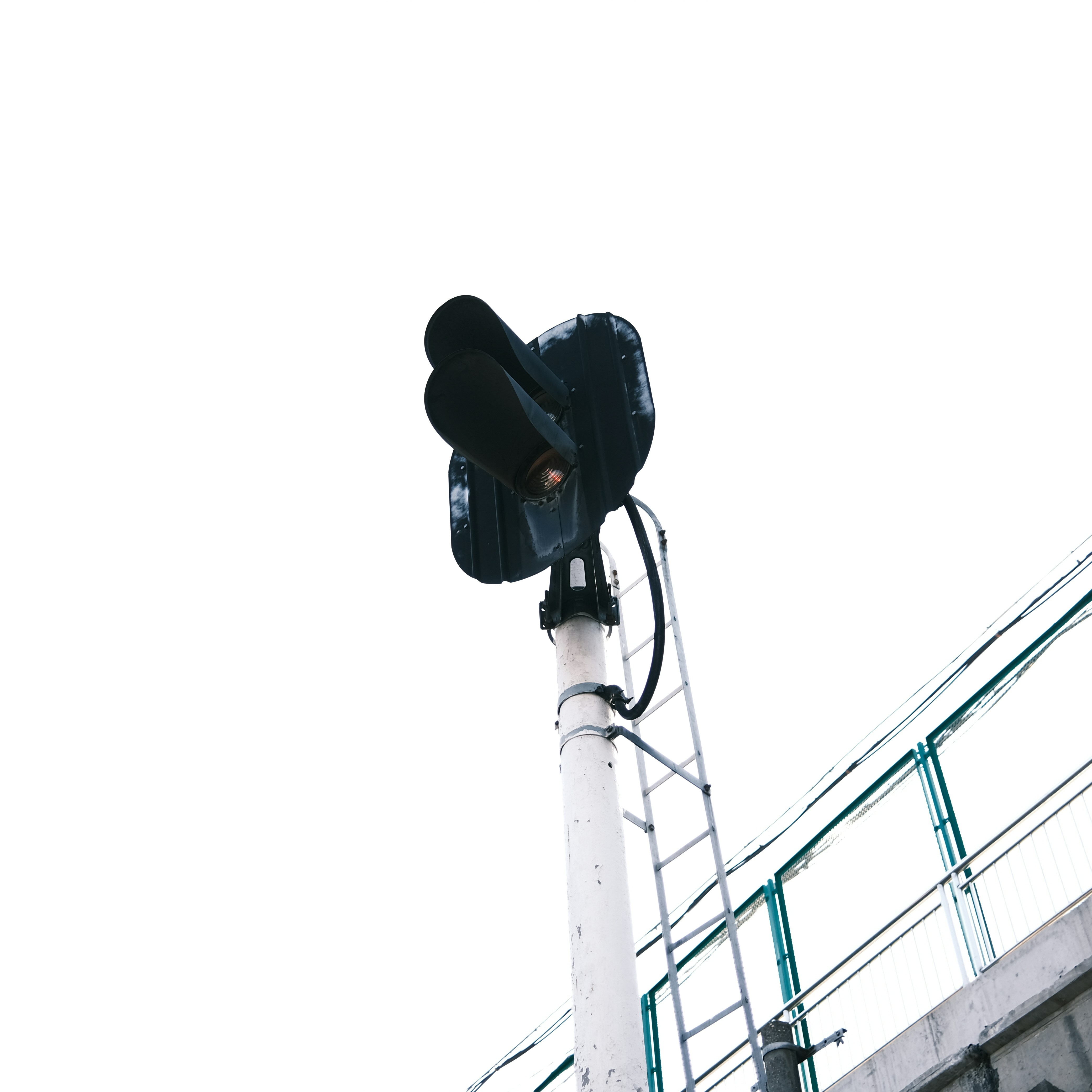 A traffic signal displaying a red light against a minimalist backdrop, emphasizing urban life’s pauses.