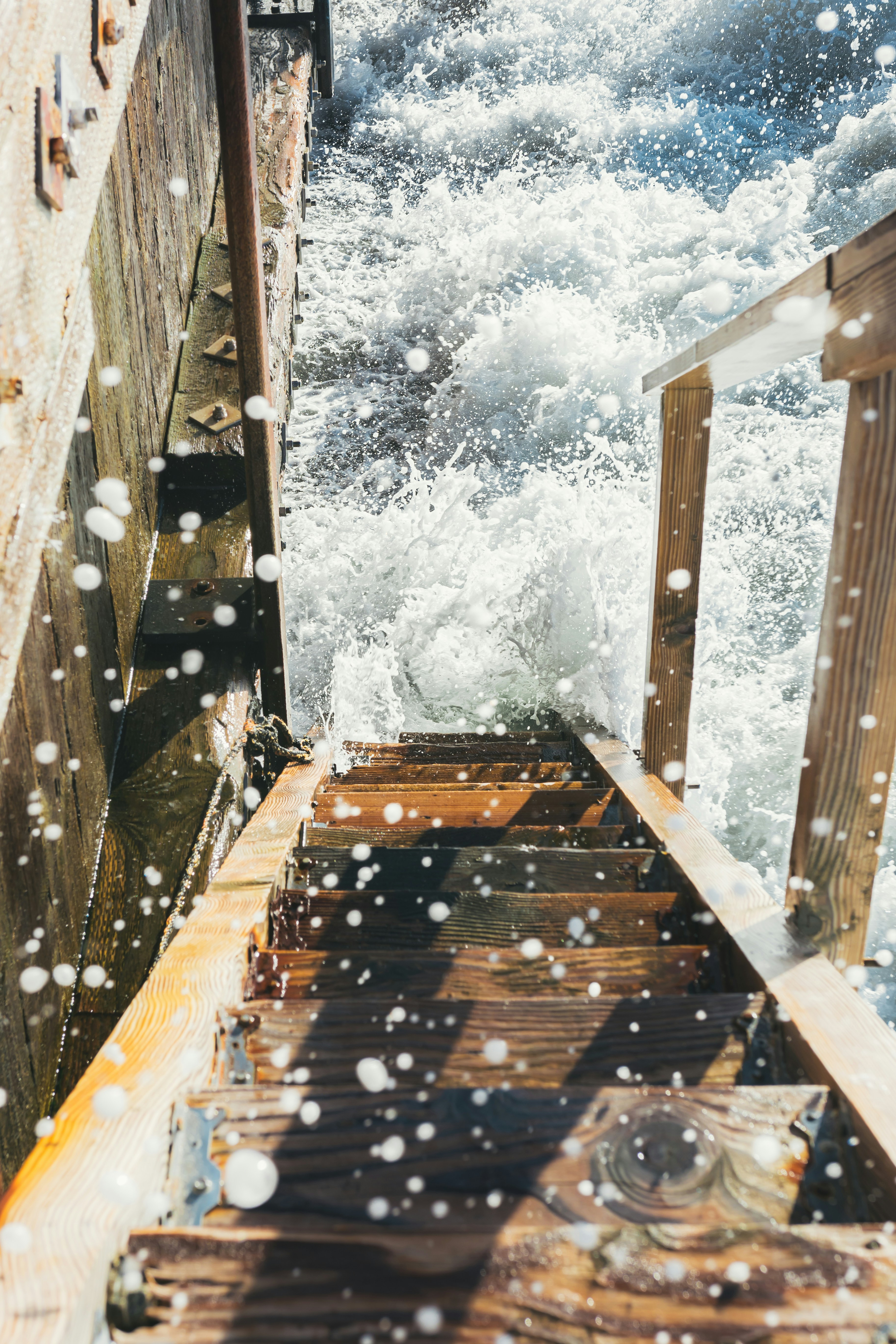 Weathered Wood Over a Snow-Dusted Whitewater Surge