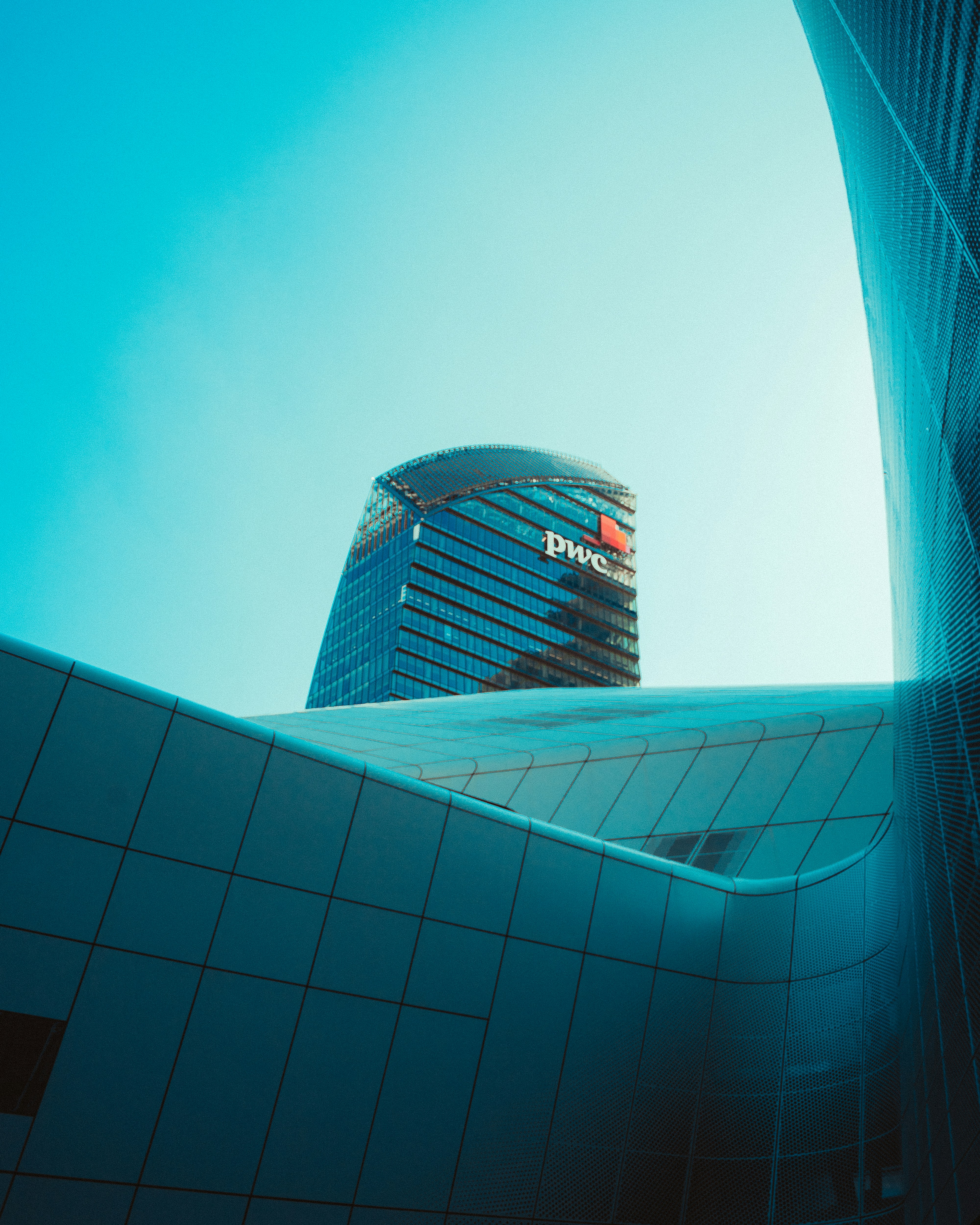 Cyan Skyline: PwC Tower Rises Behind a Fluid Curved Facade