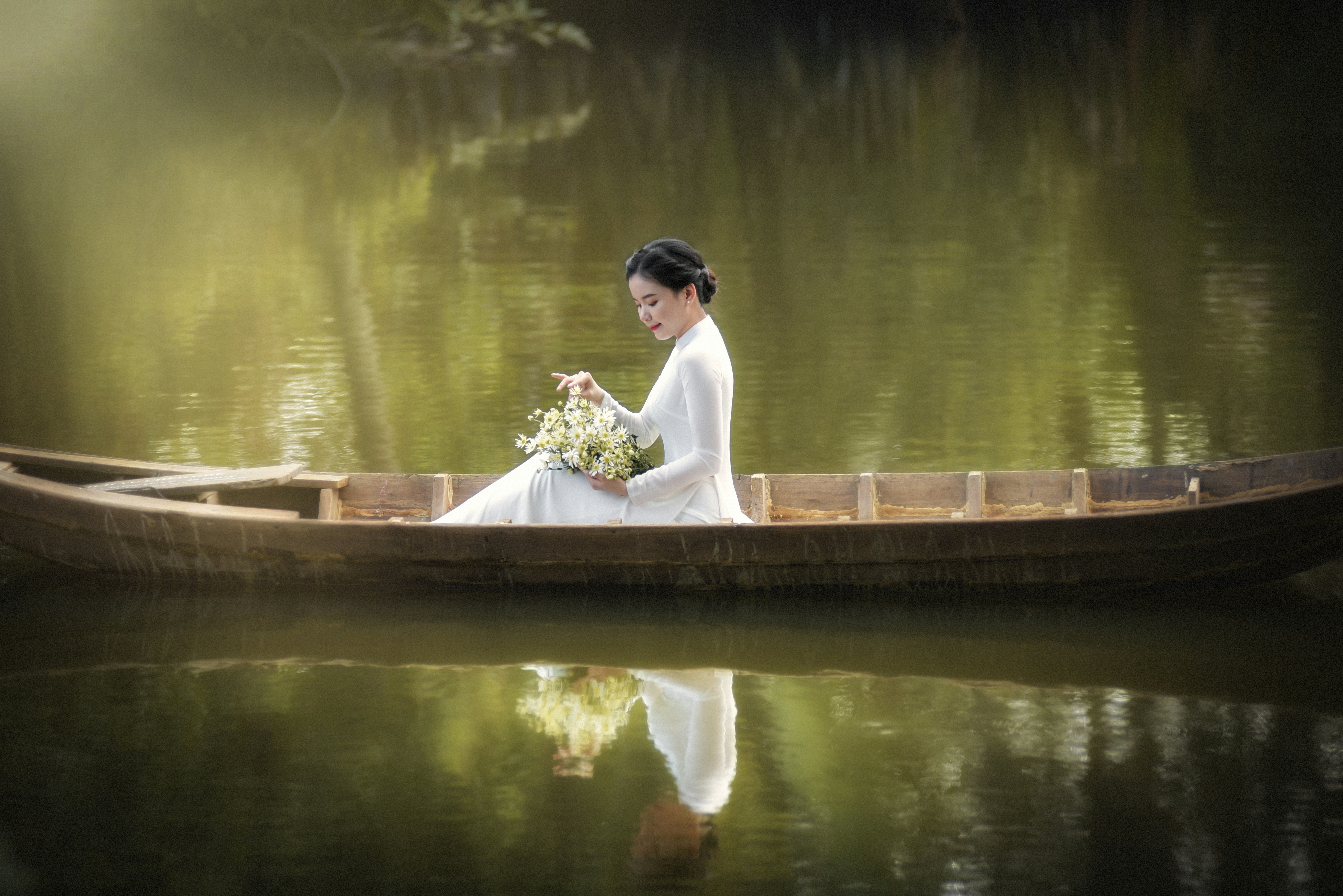 man in white dress shirt sitting on brown wooden dock during daytime