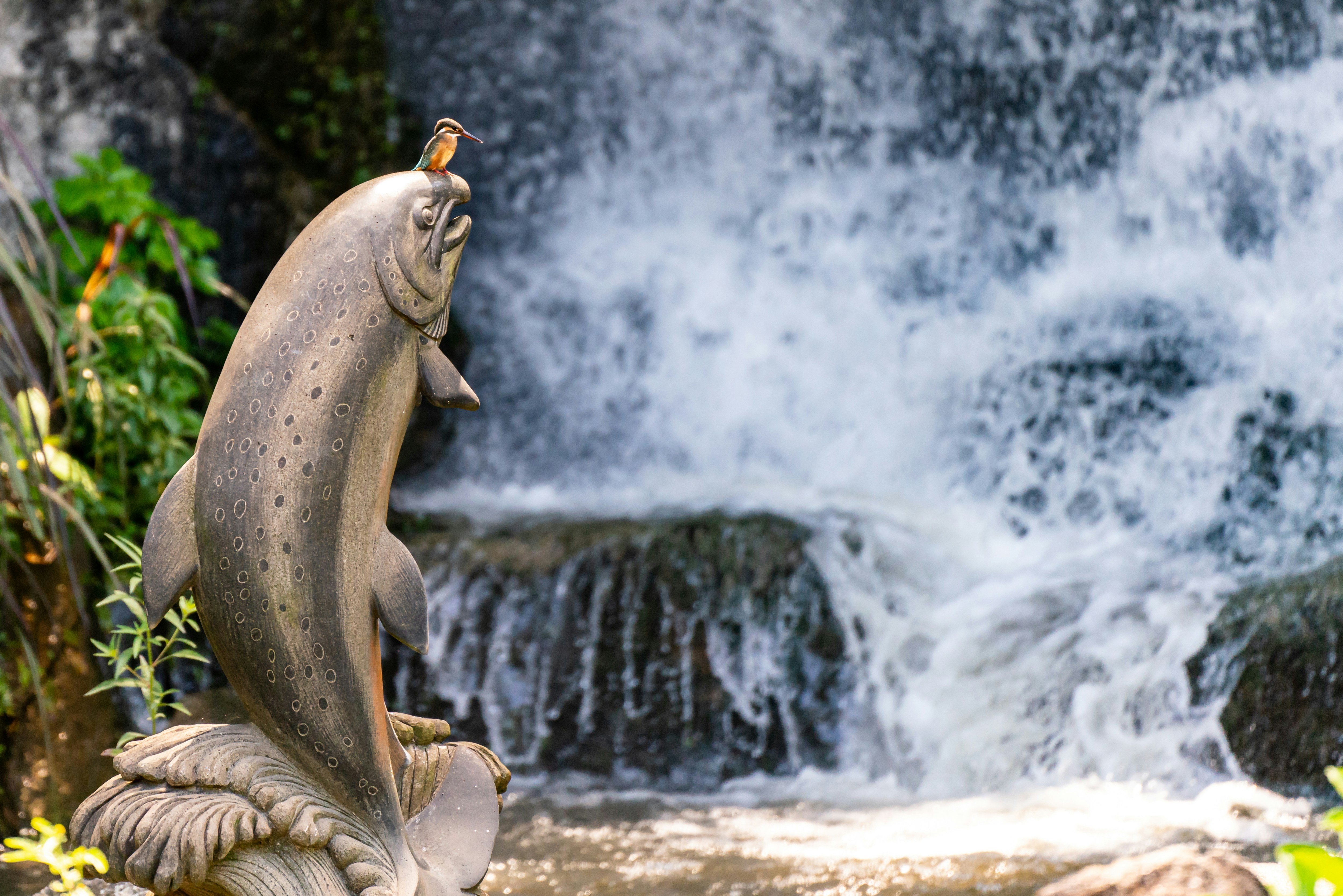 gray elephant statue near water falls during daytime