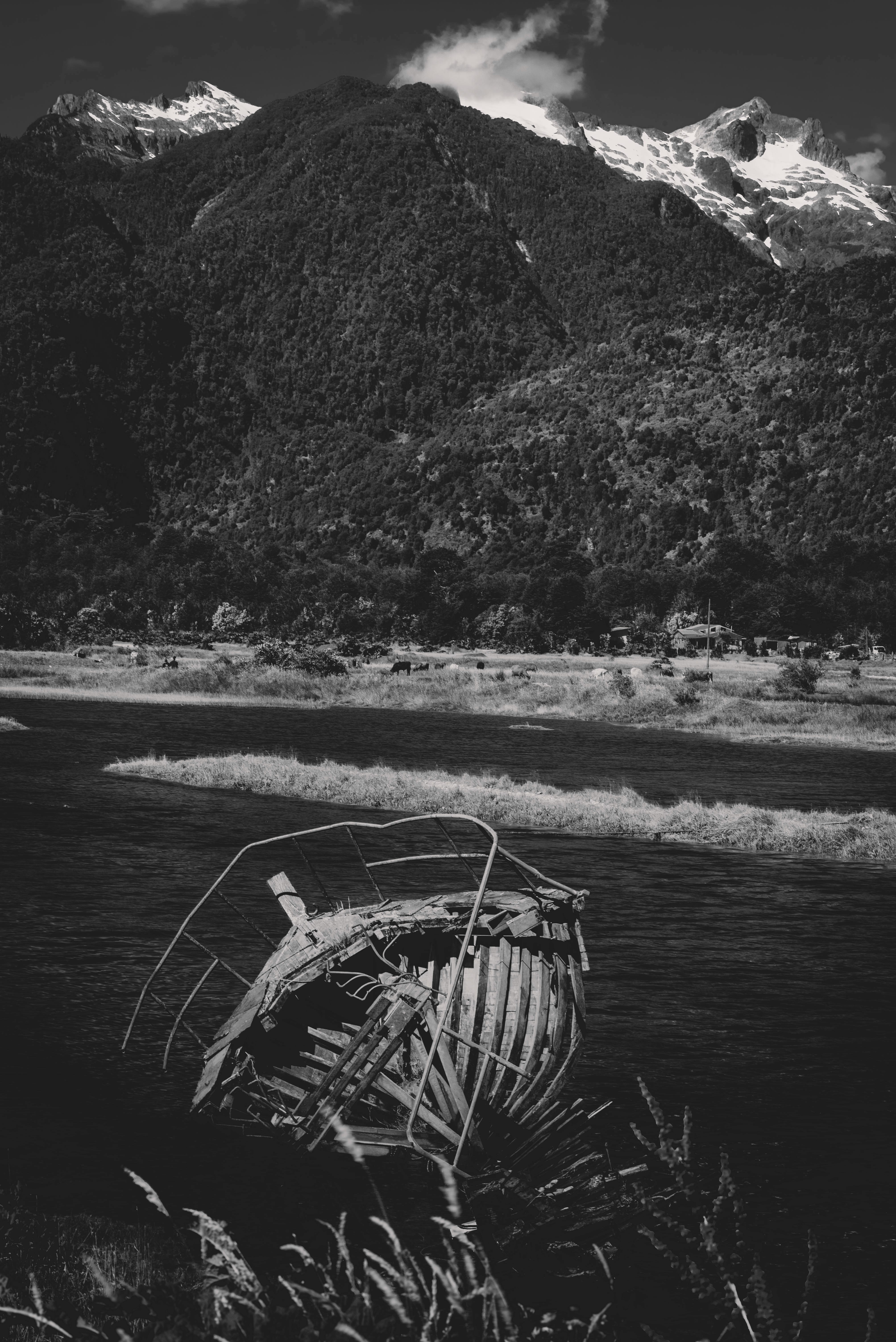 Ruined Skiff Adrift at the Lake’s Edge Beneath Snow-Crowned Peaks