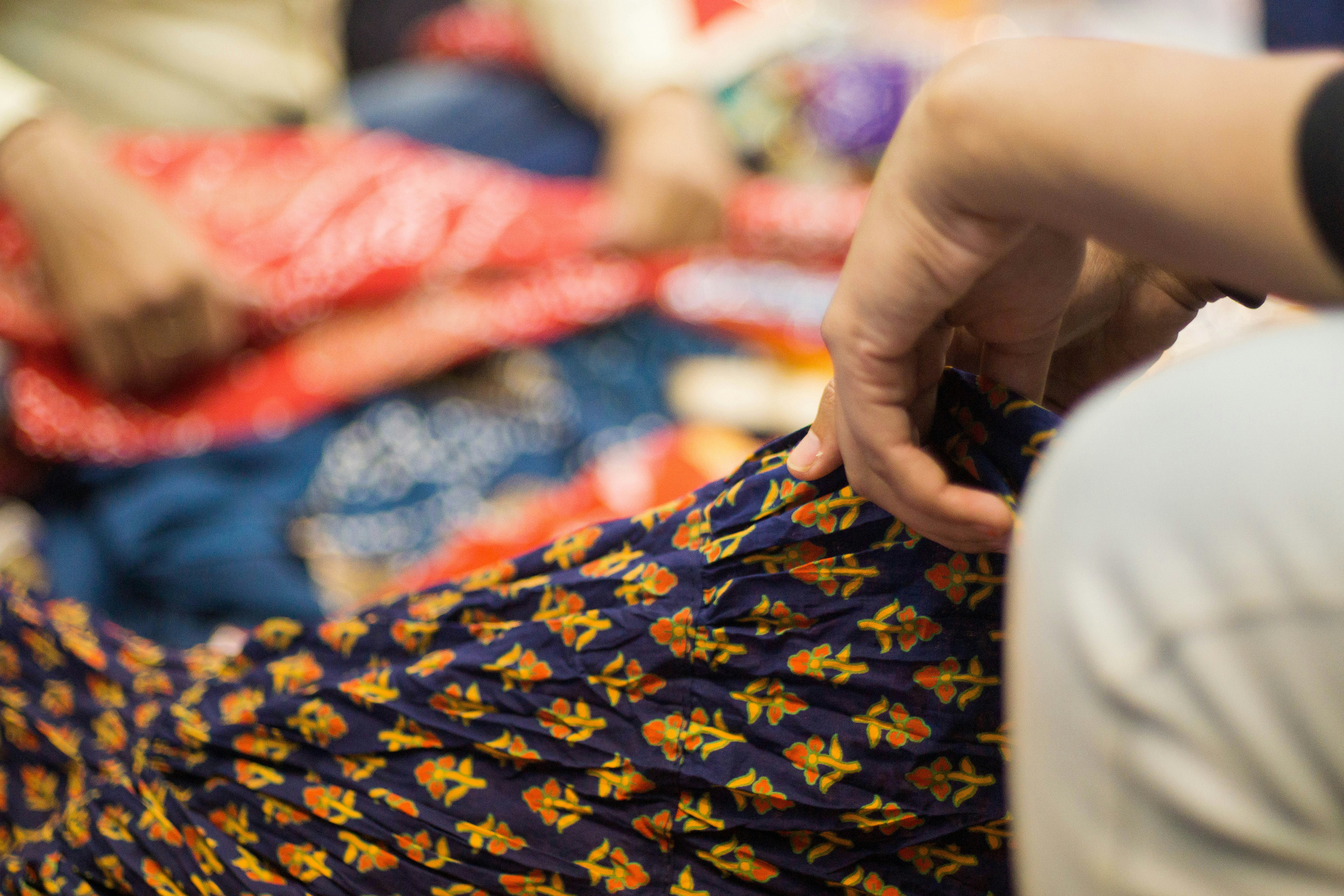 In the Fold: a close-up of a hand guiding patterned fabric