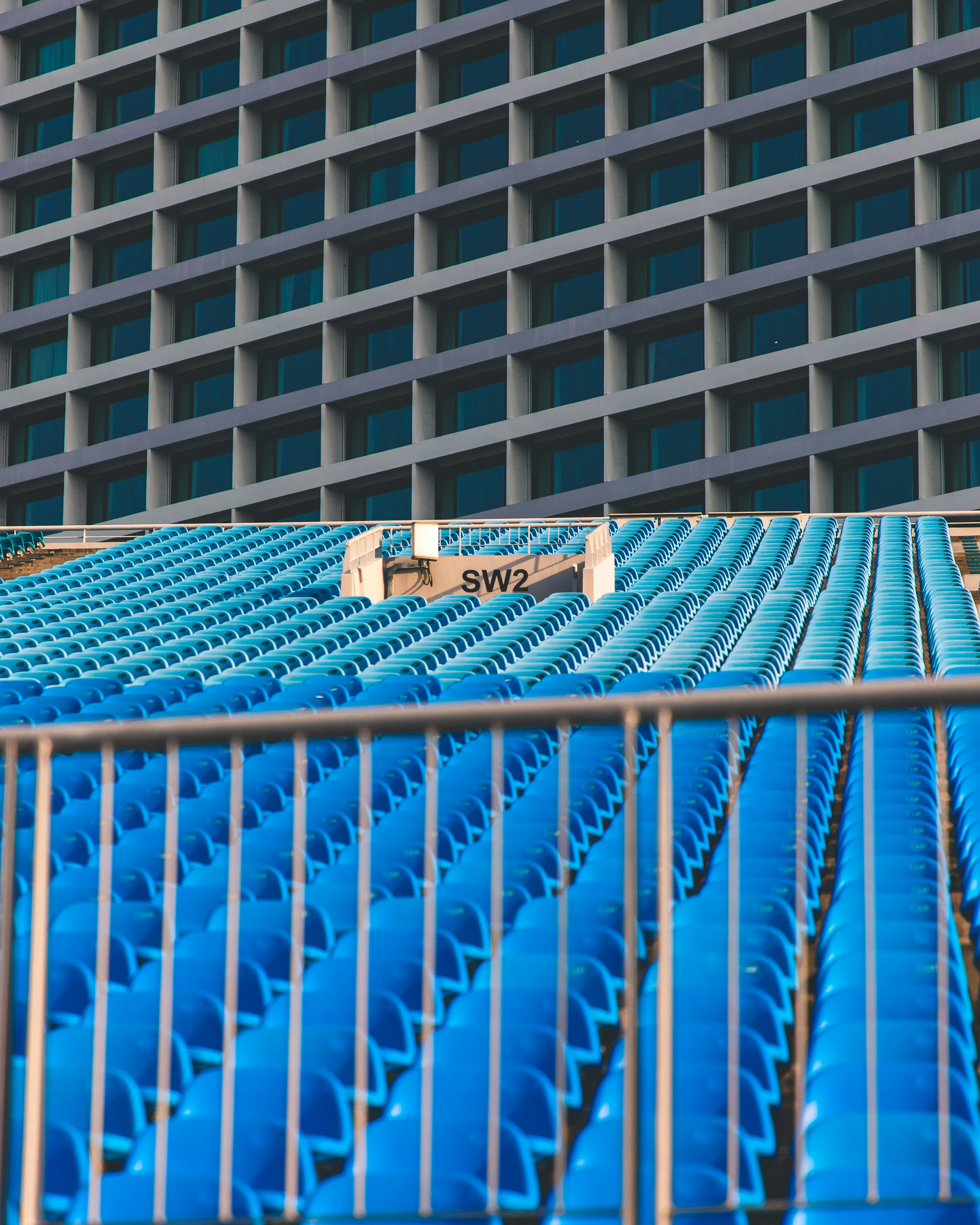Converging Azure Seats: A Quiet Geometry of Blue against a Modern Facade