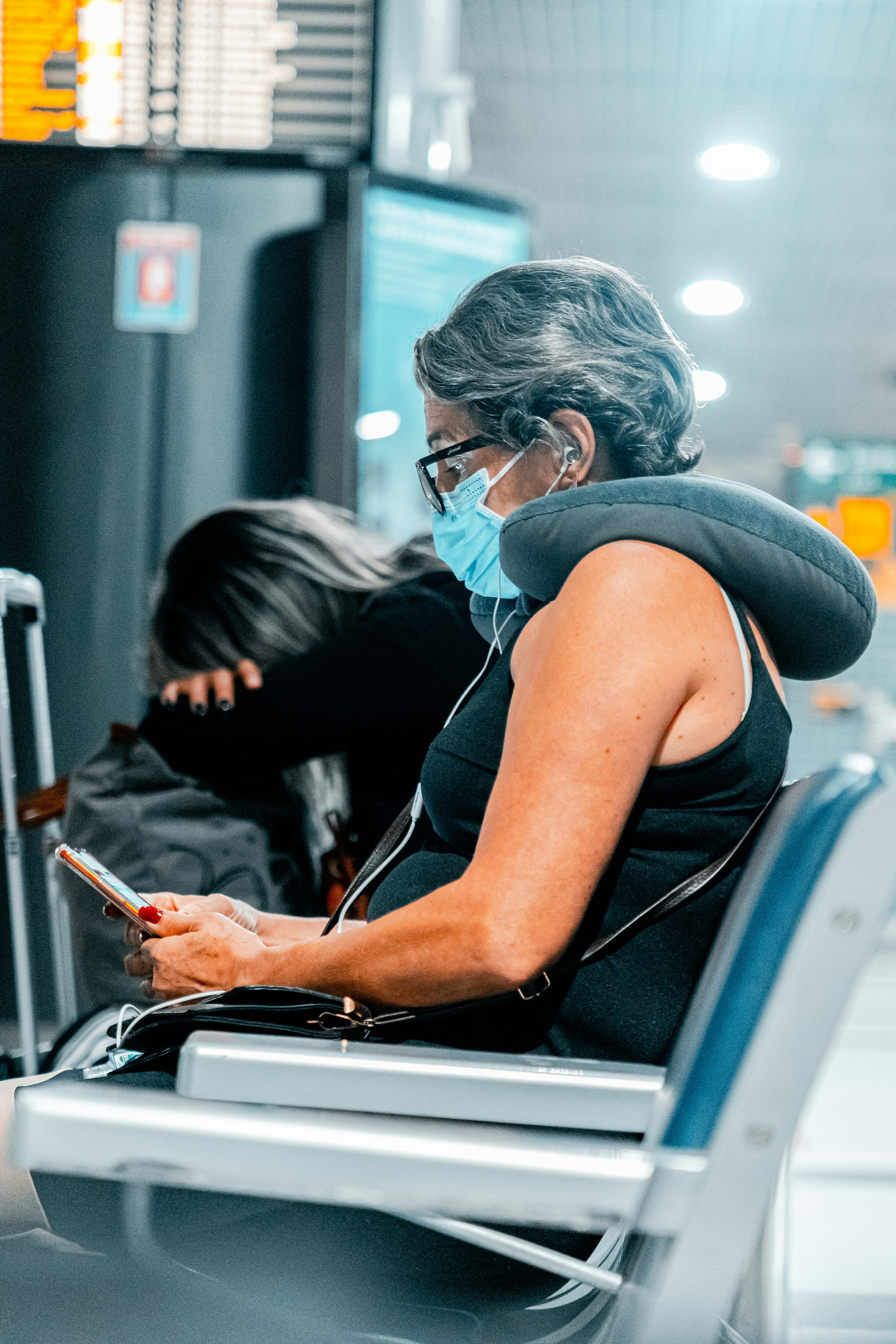 Pulse in the Terminal: A Masked Traveler Focused on a Phone
