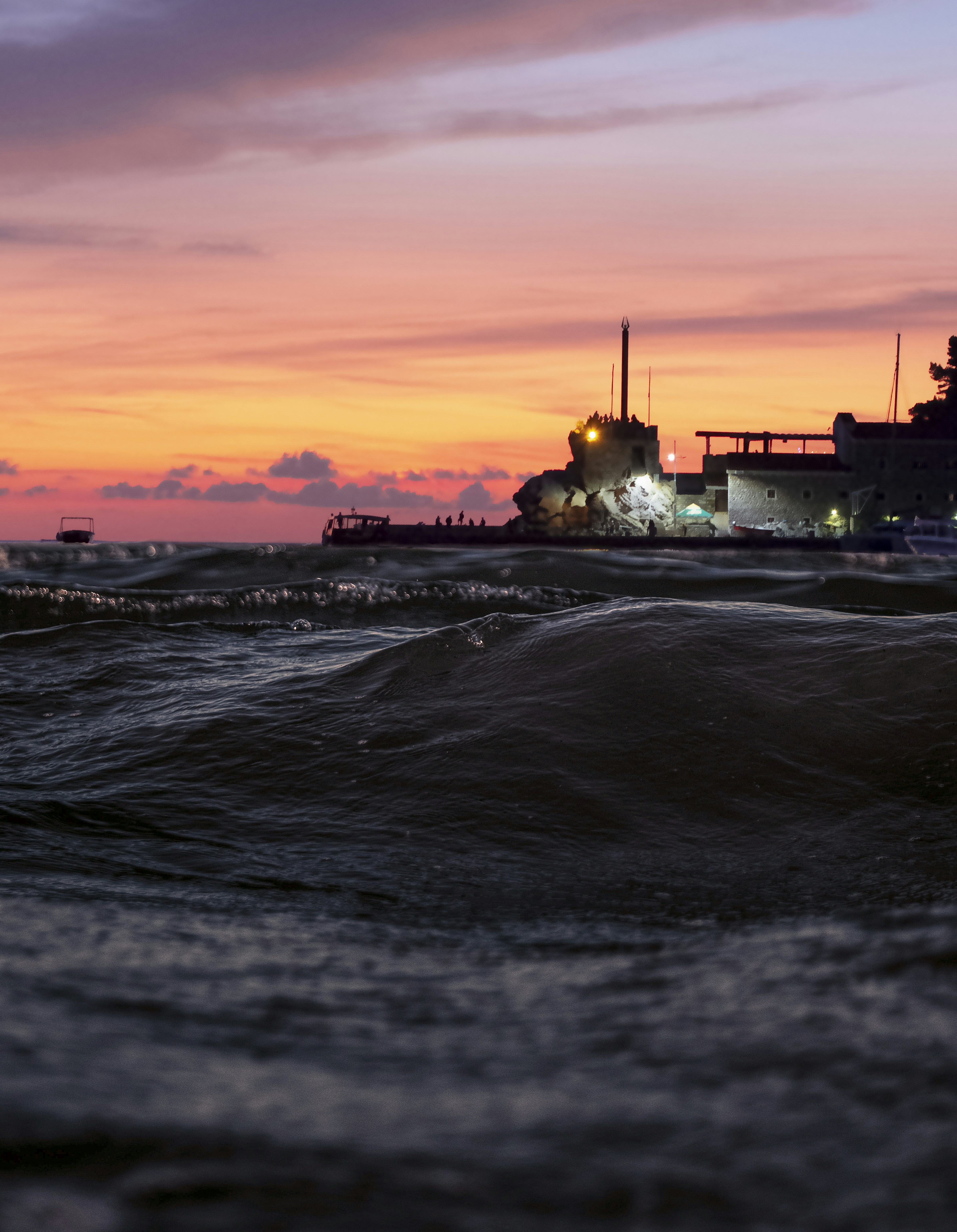 Ember Harbor at Dusk: Illumed Structures Amid Rolling Seas