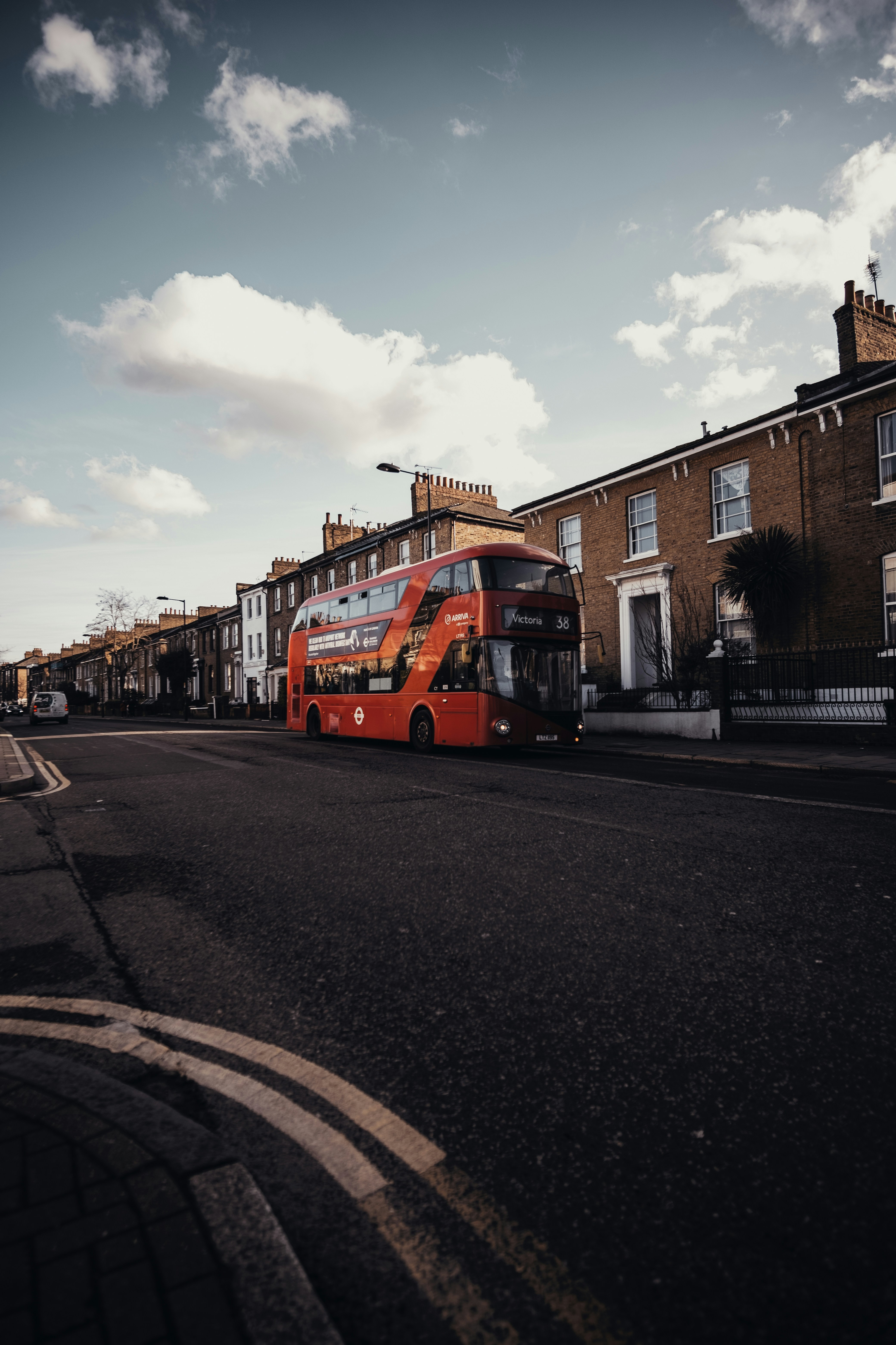 Red double-decker on a brick-lined street at late-afternoon hush