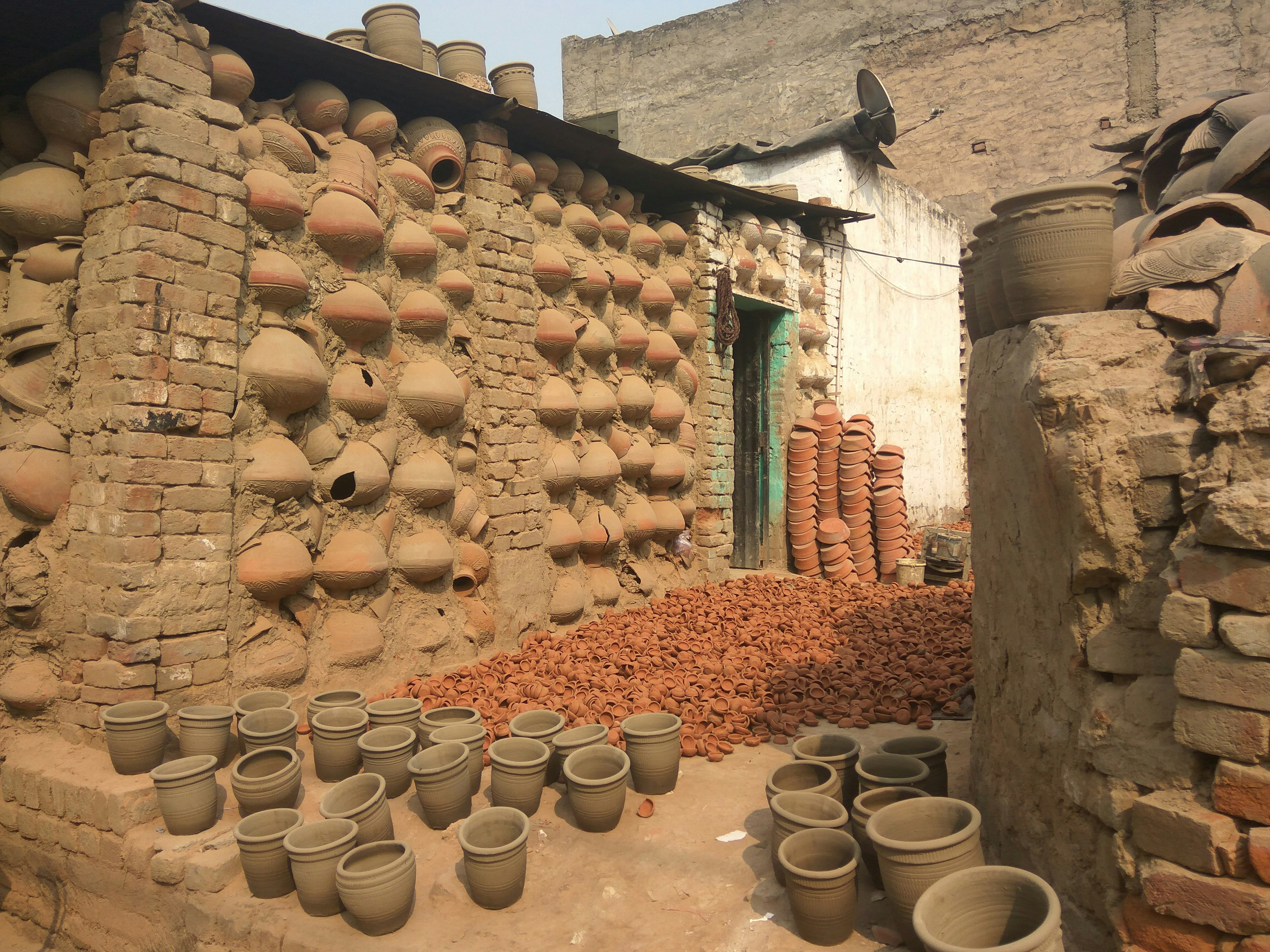 Sunlit Pottery Alley: Piles of Jars Framing a Humble Doorway