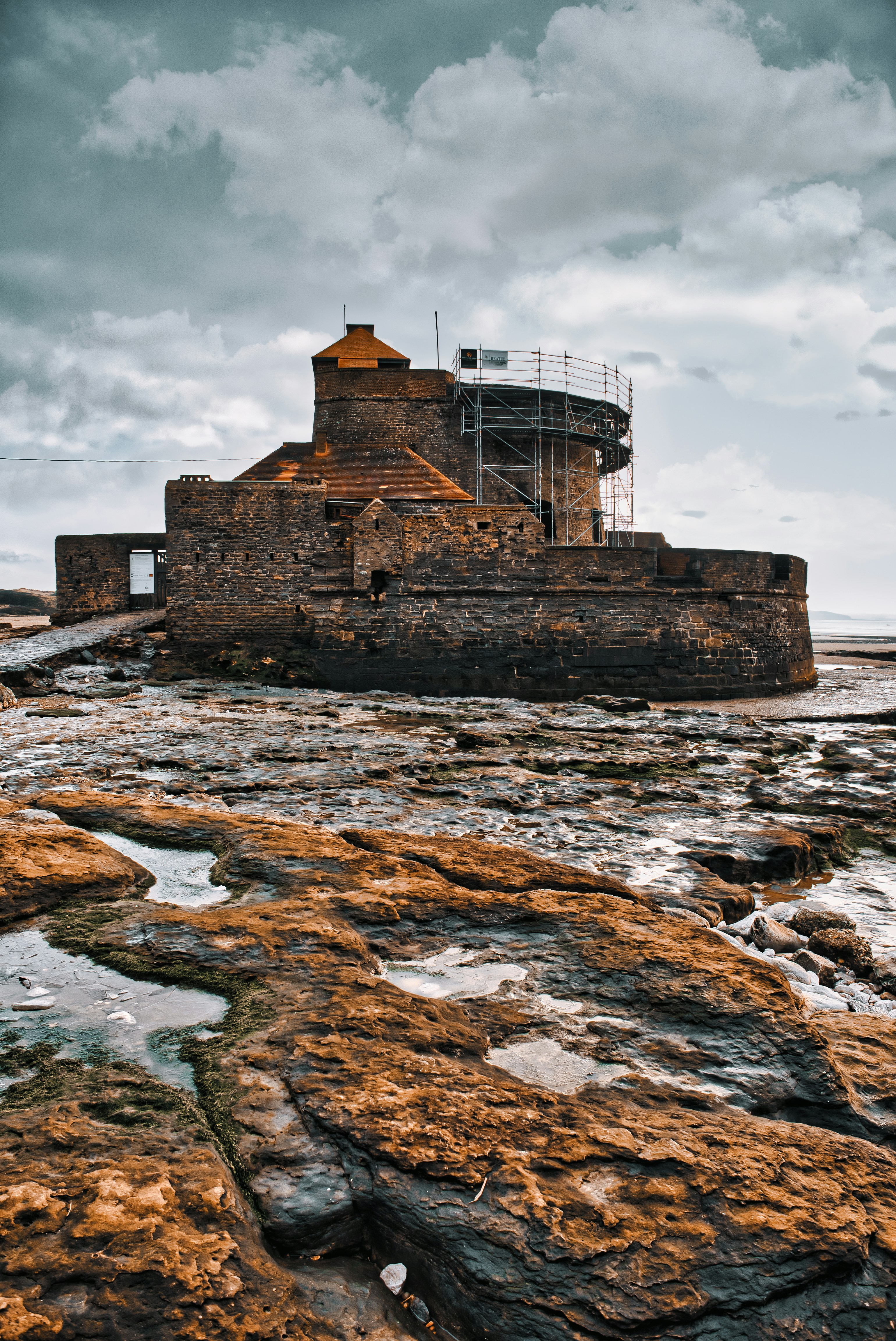 Seaward Bastion: Weathered Stone Fort with Scaffolding Against a Tempestuous Sky