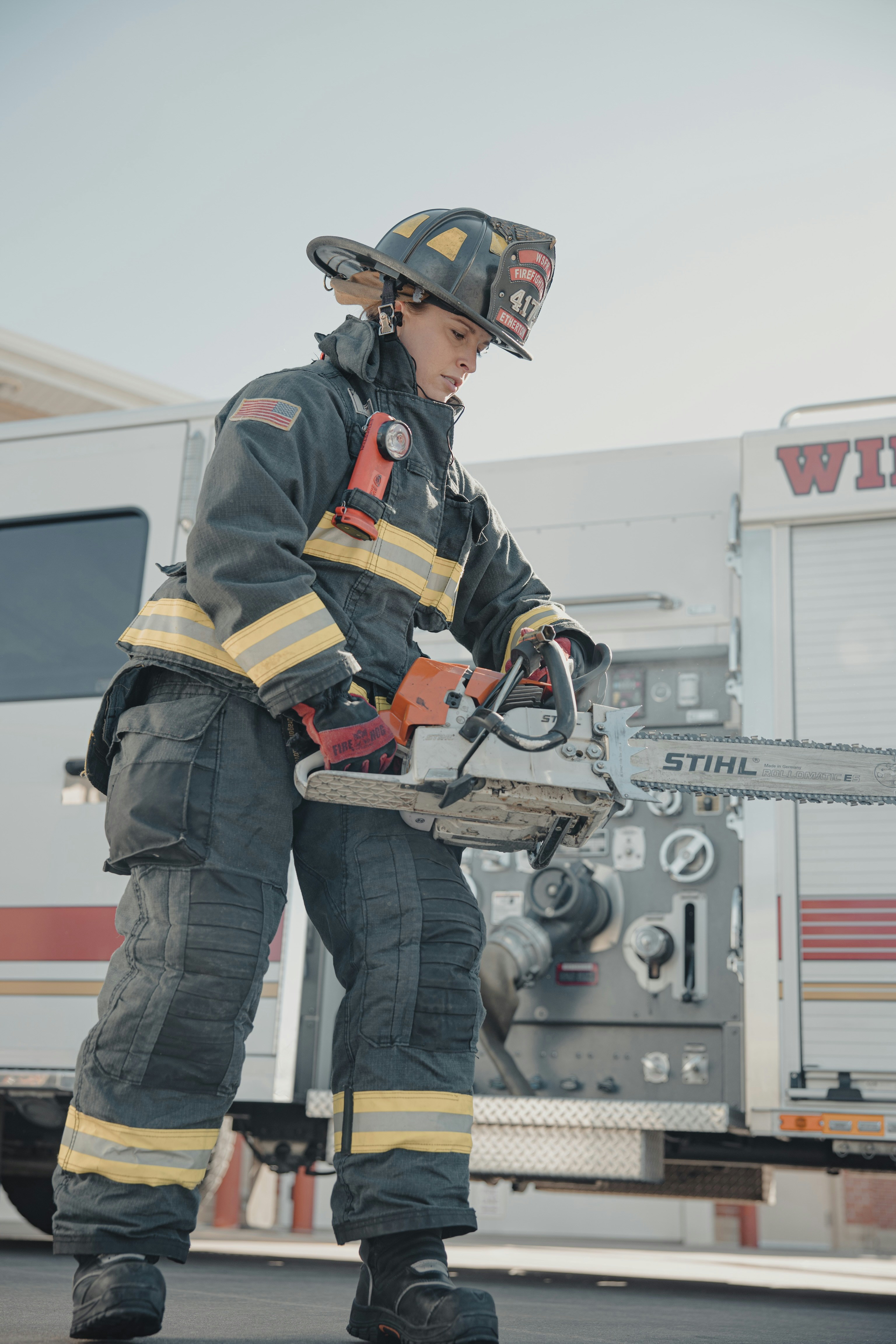 A firefighter standing in front of a fire truck photo – Free Grey Image ...