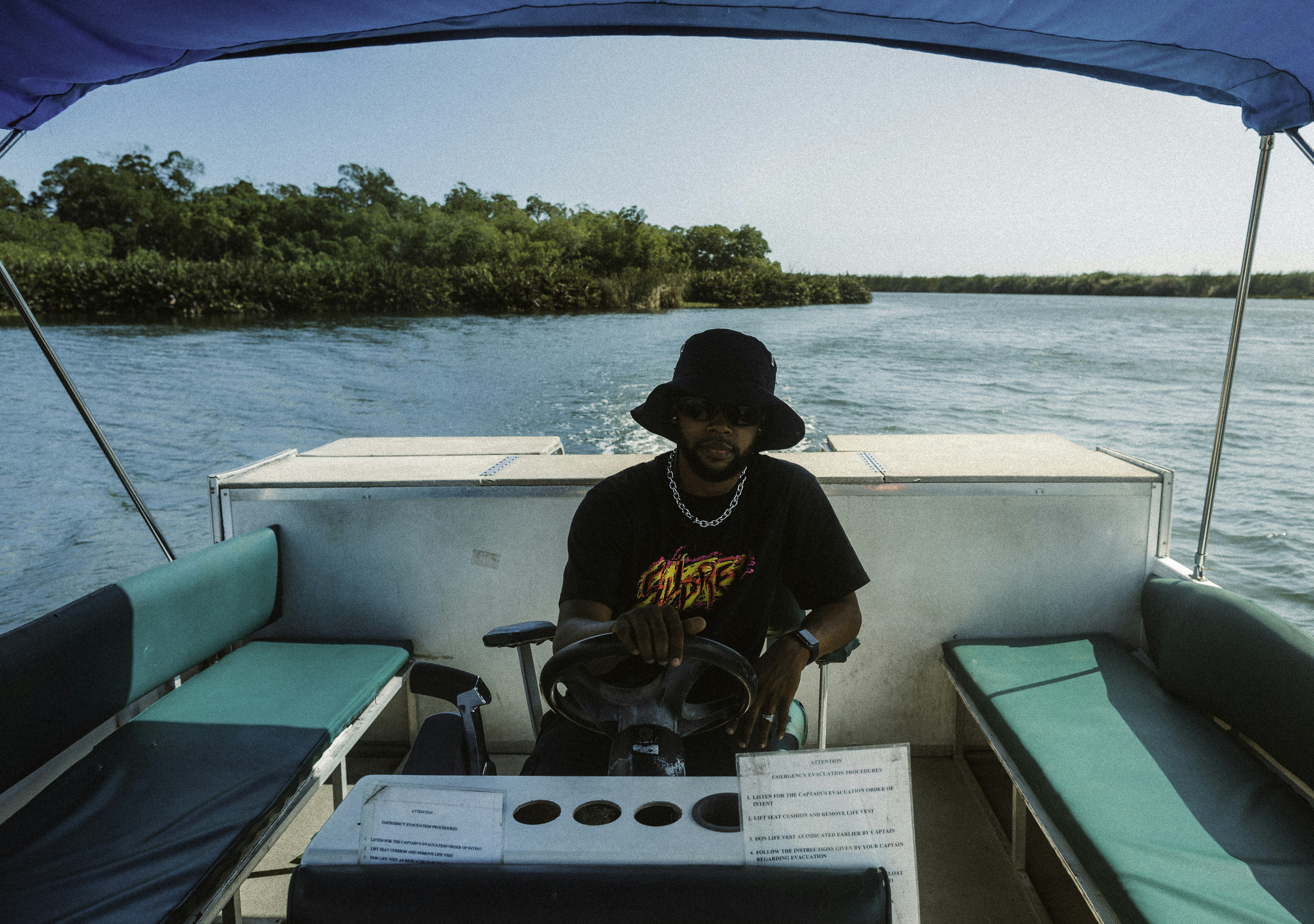 man in black and yellow crew neck t-shirt sitting on boat during daytime