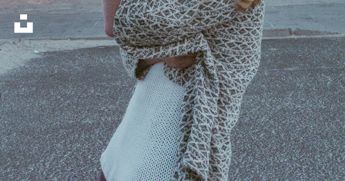 黒と白のヒョウ柄の長袖シャツと白のズボンを着た女性が灰色に座っているの写真 Unsplashのファッションの無料画像