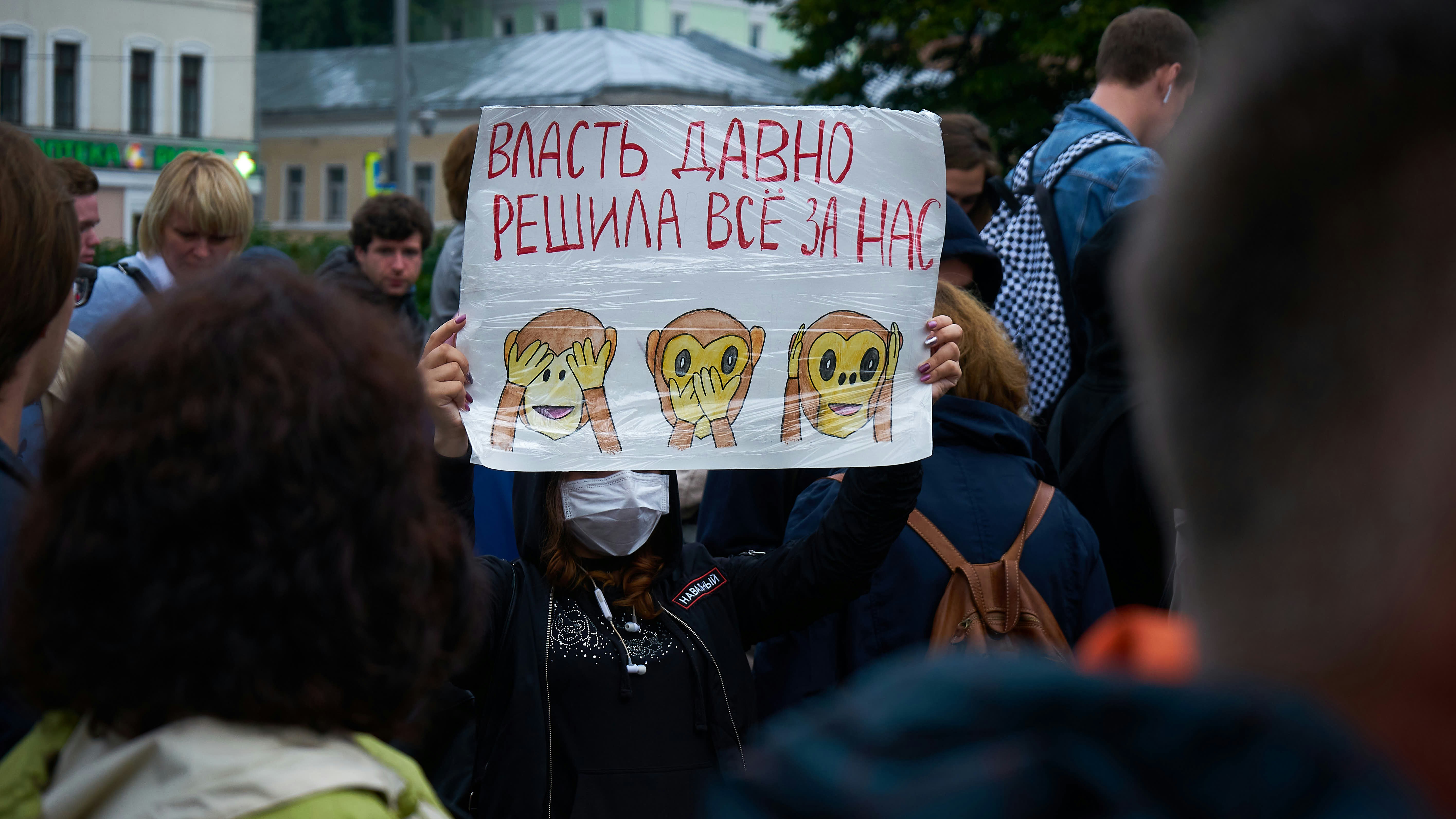 Sign of Dissent: Three Emoji Faces Under a Provocative Message in a City Protest