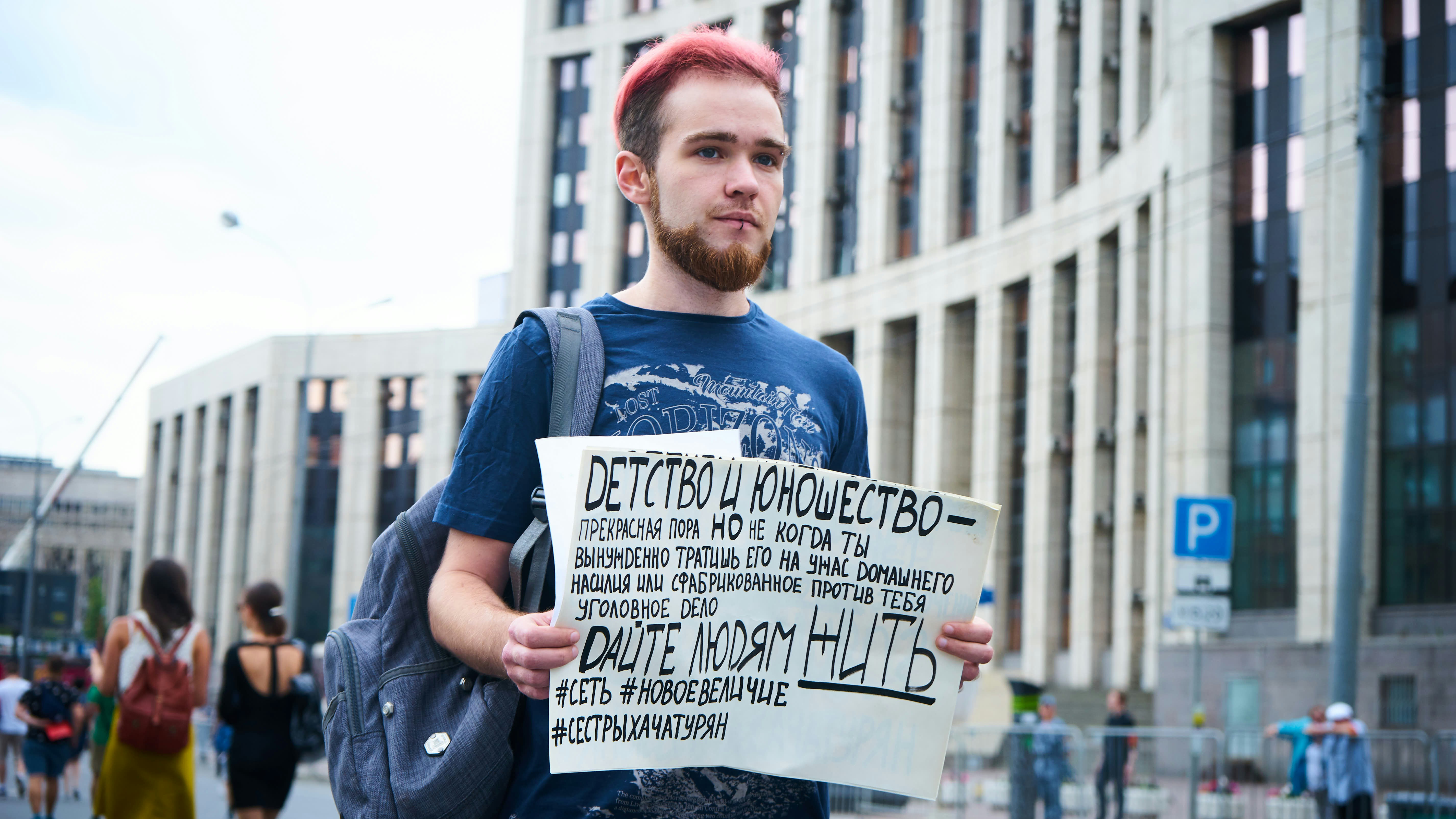Young activist holding a sign advocating for youth rights in a city square during a demonstration.