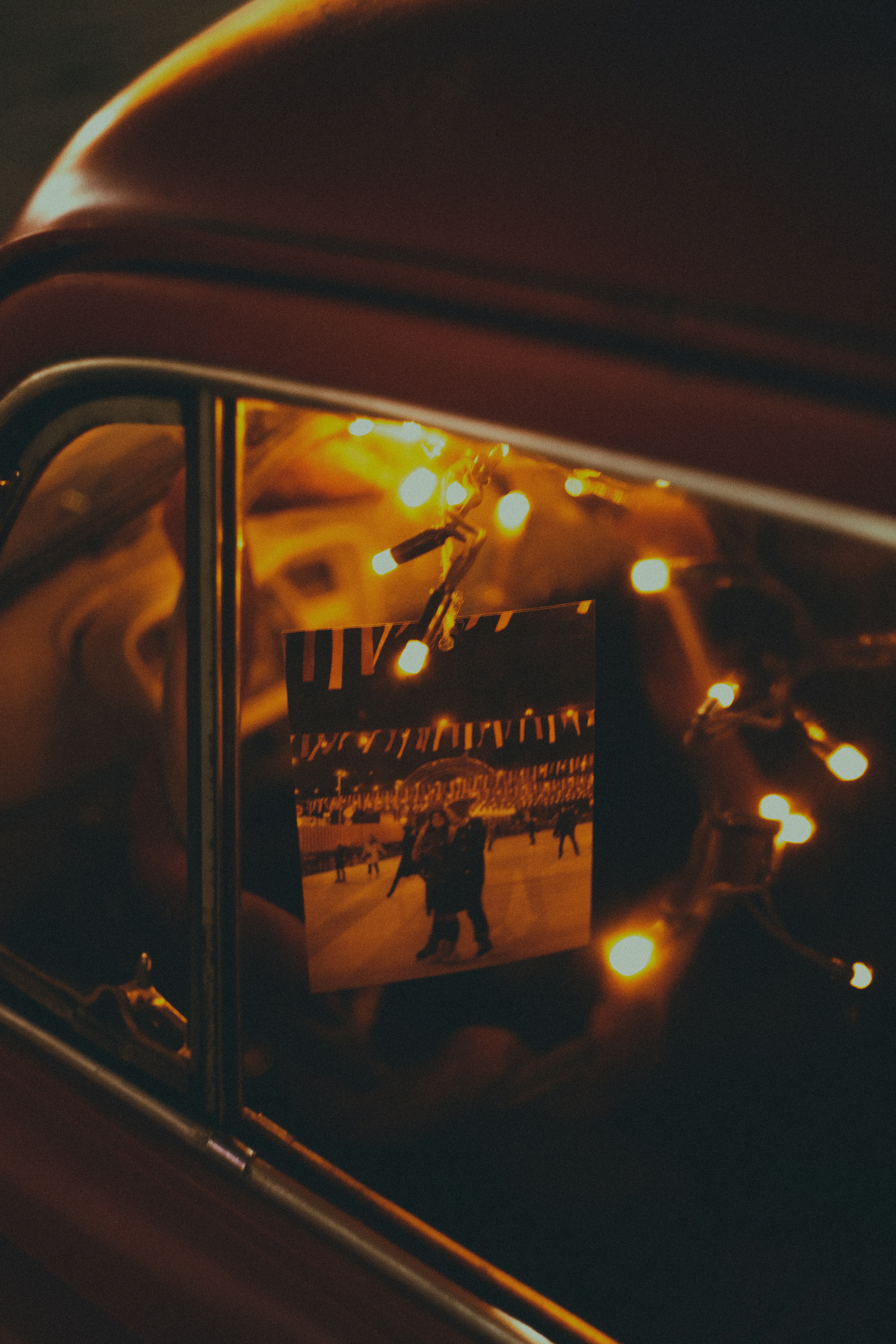 Warm Echoes on Glass: a tiny photo haloed by fairy lights in a vintage car