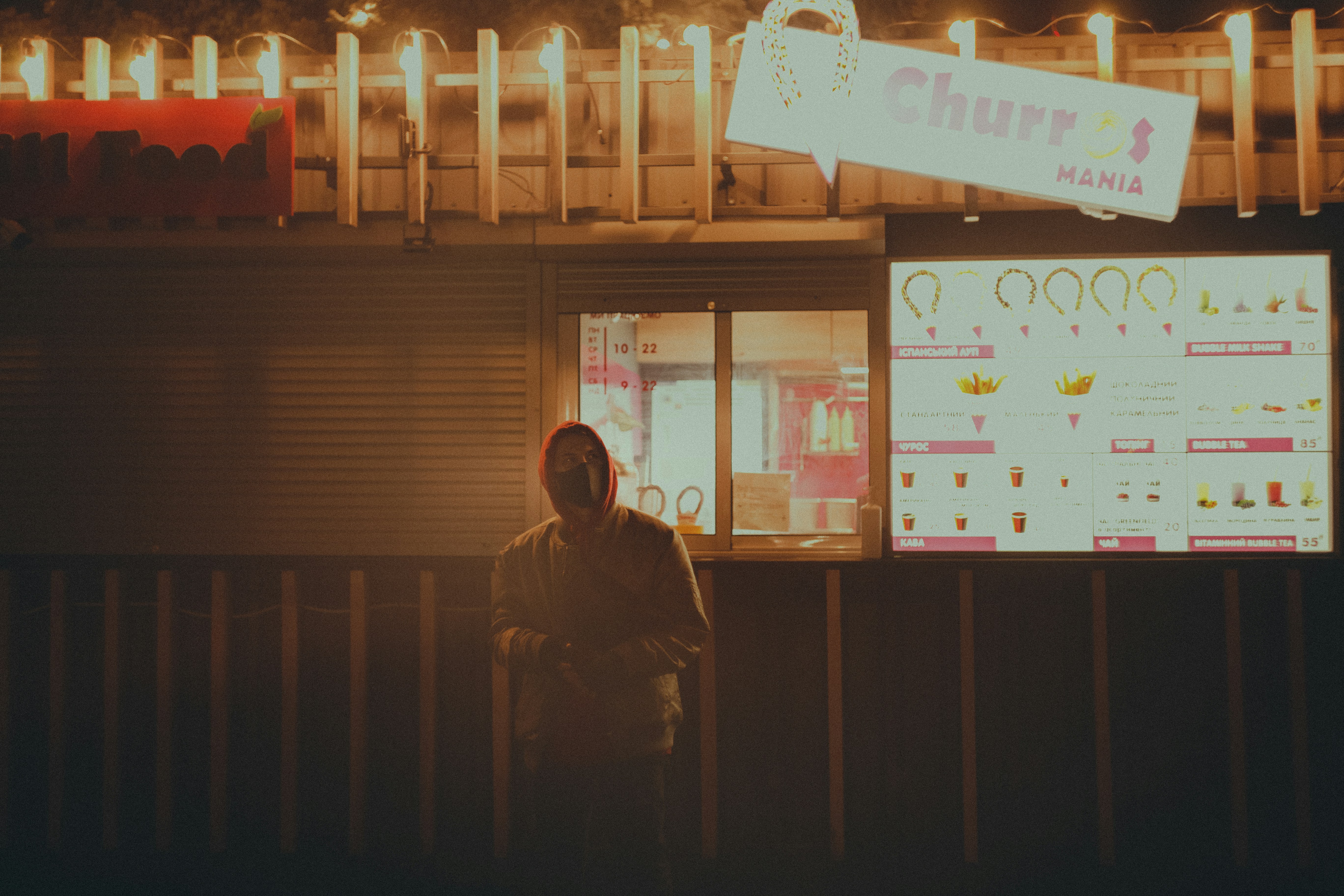 Nightfront at Churr's Stand: A solitary figure beneath warm signage