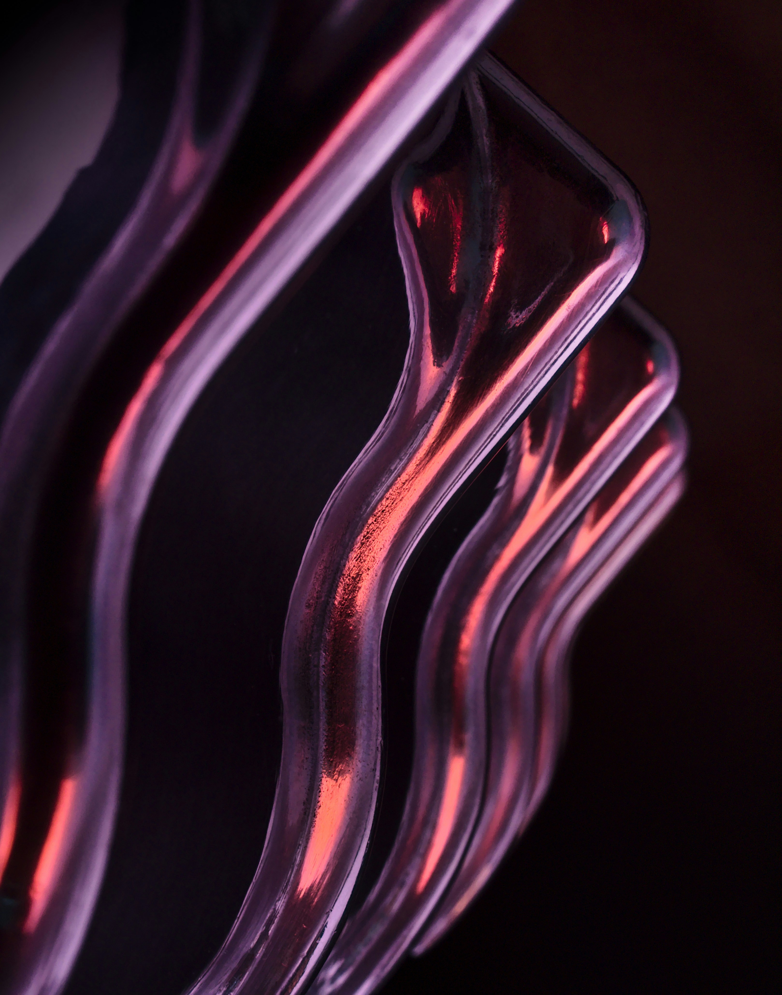 Abstract close-up of a cast aluminum griddle part illuminated by vibrant multicolored lights.