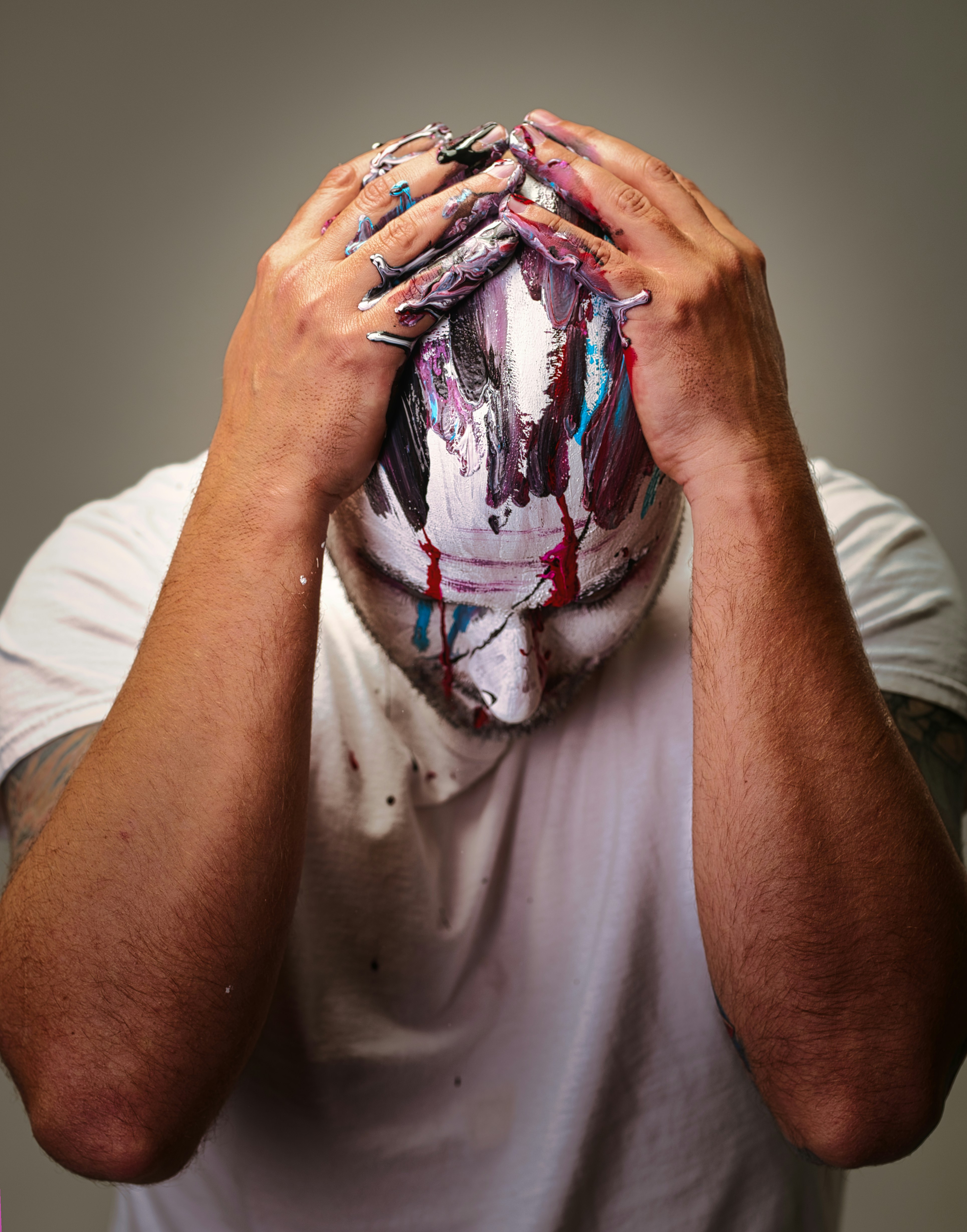 Hands Clutching a Painted Mask of Anxiety