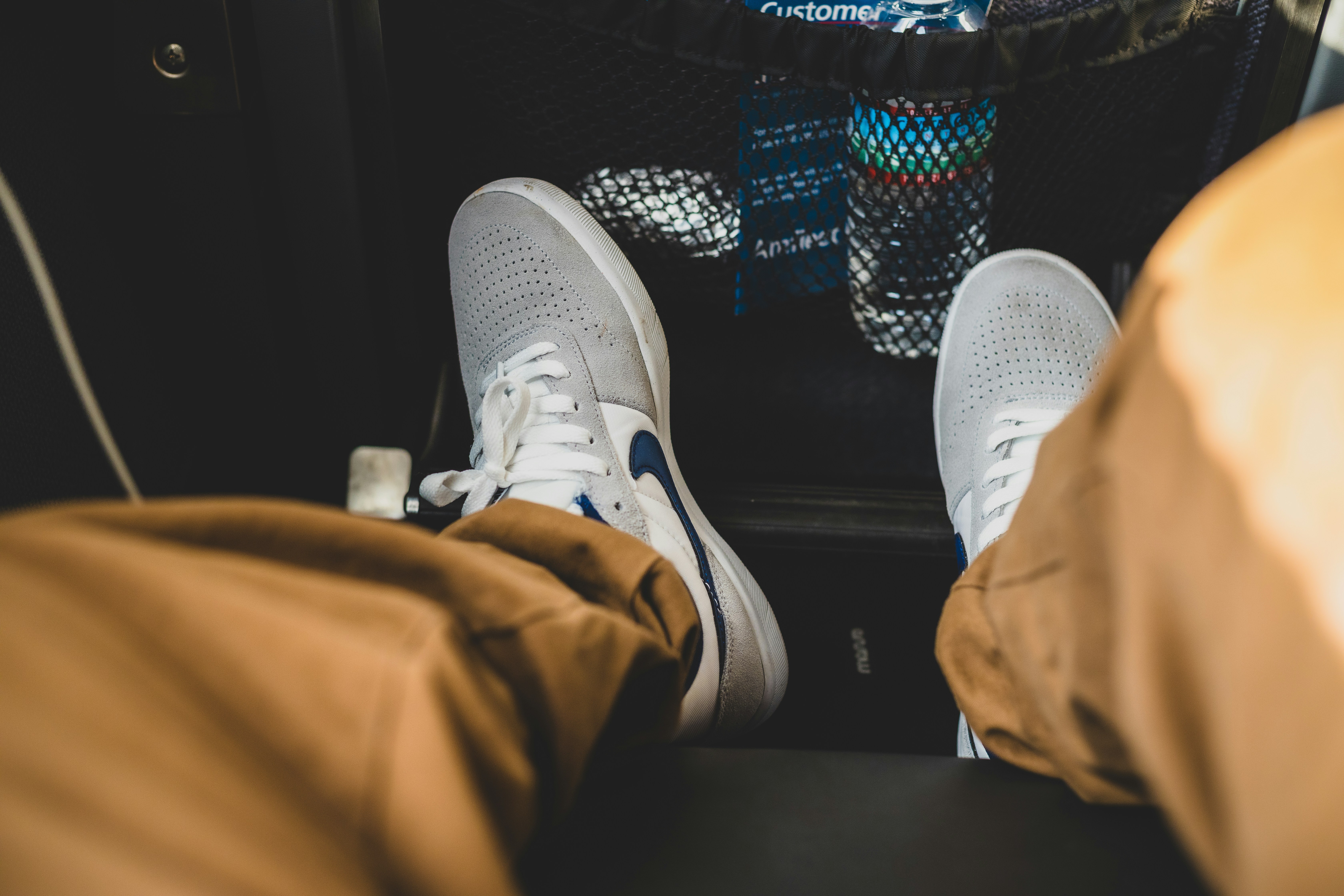 Ground-Level Pause: White Sneakers in a Quiet Car Cabin