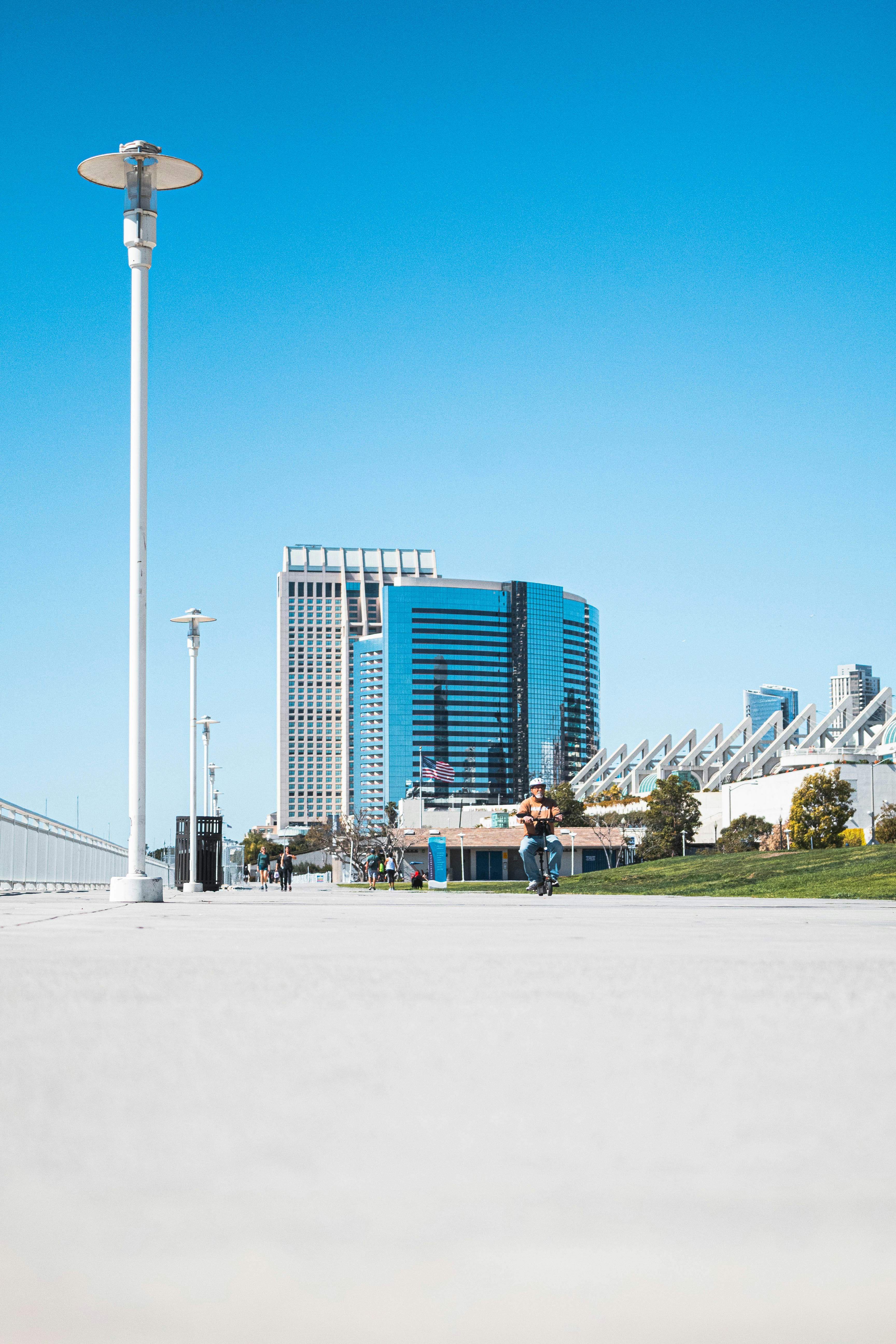 People walking on sidewalk near high rise buildings during daytime ...