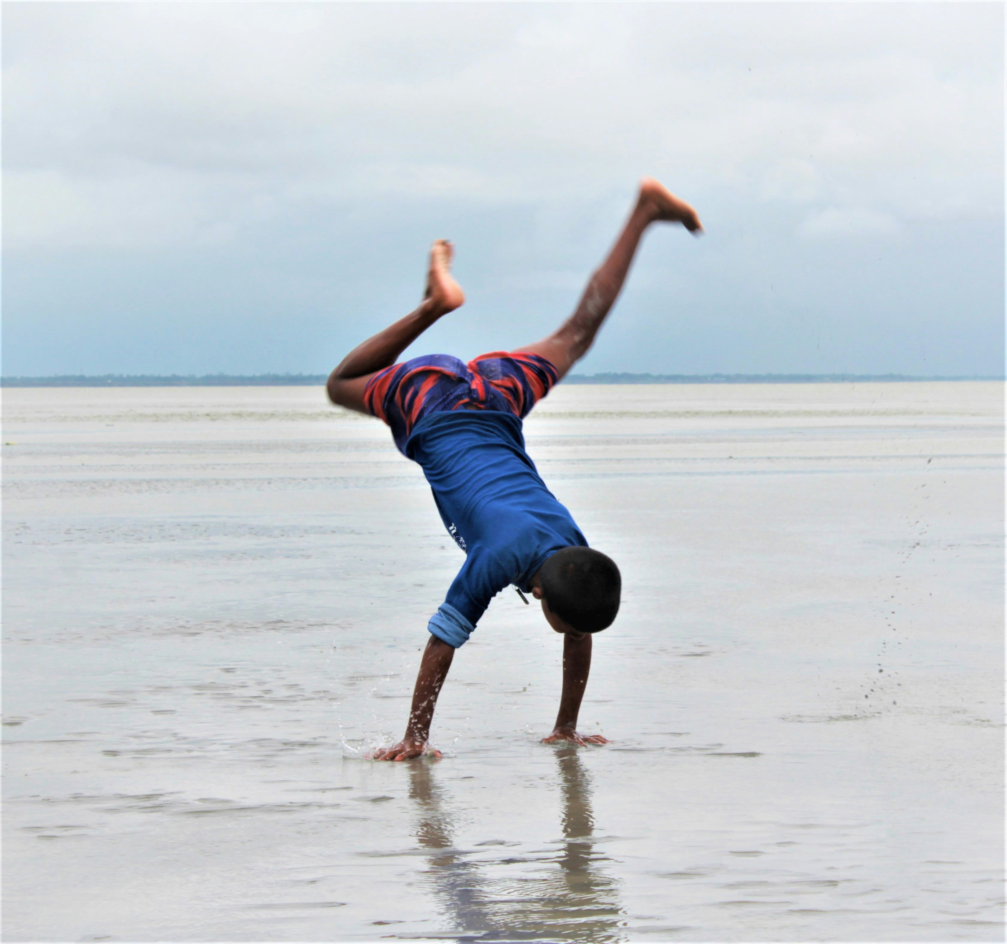 man in blue t-shirt and blue shorts lying on water during daytime