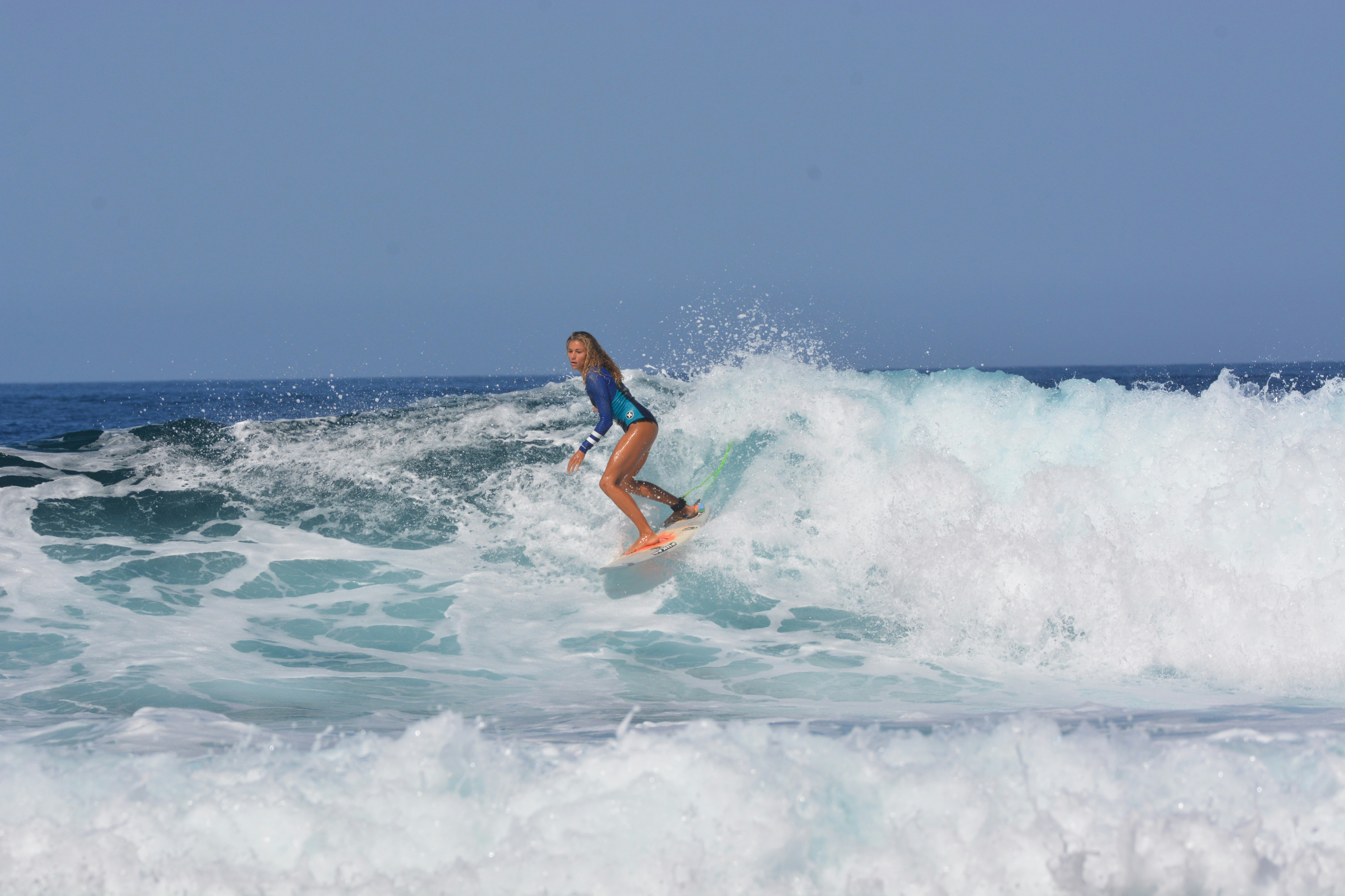 Woman in blue and white bikini surfing on sea waves during daytime ...