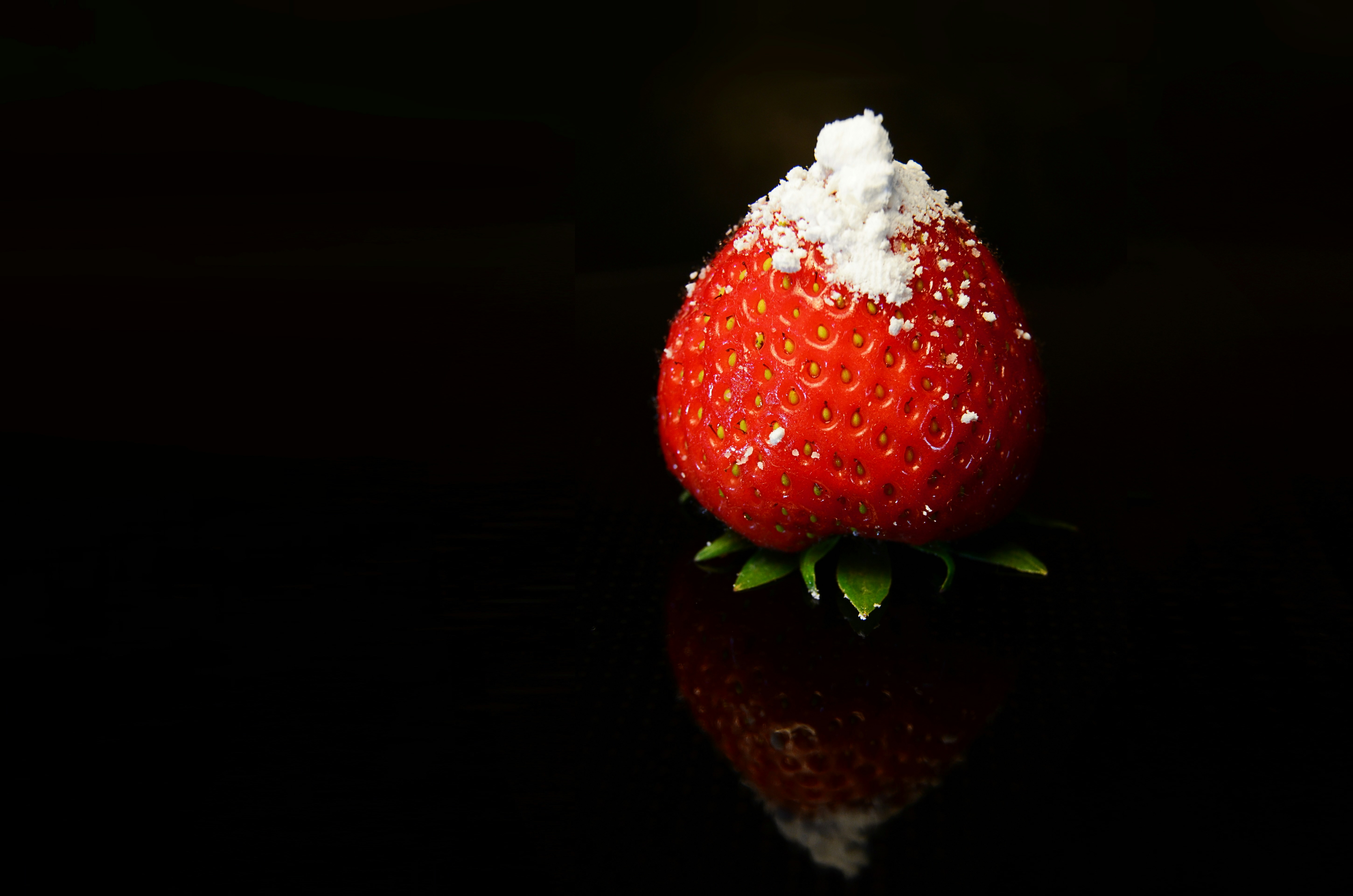 Strawberry Spotlight: a lone berry on a black stage