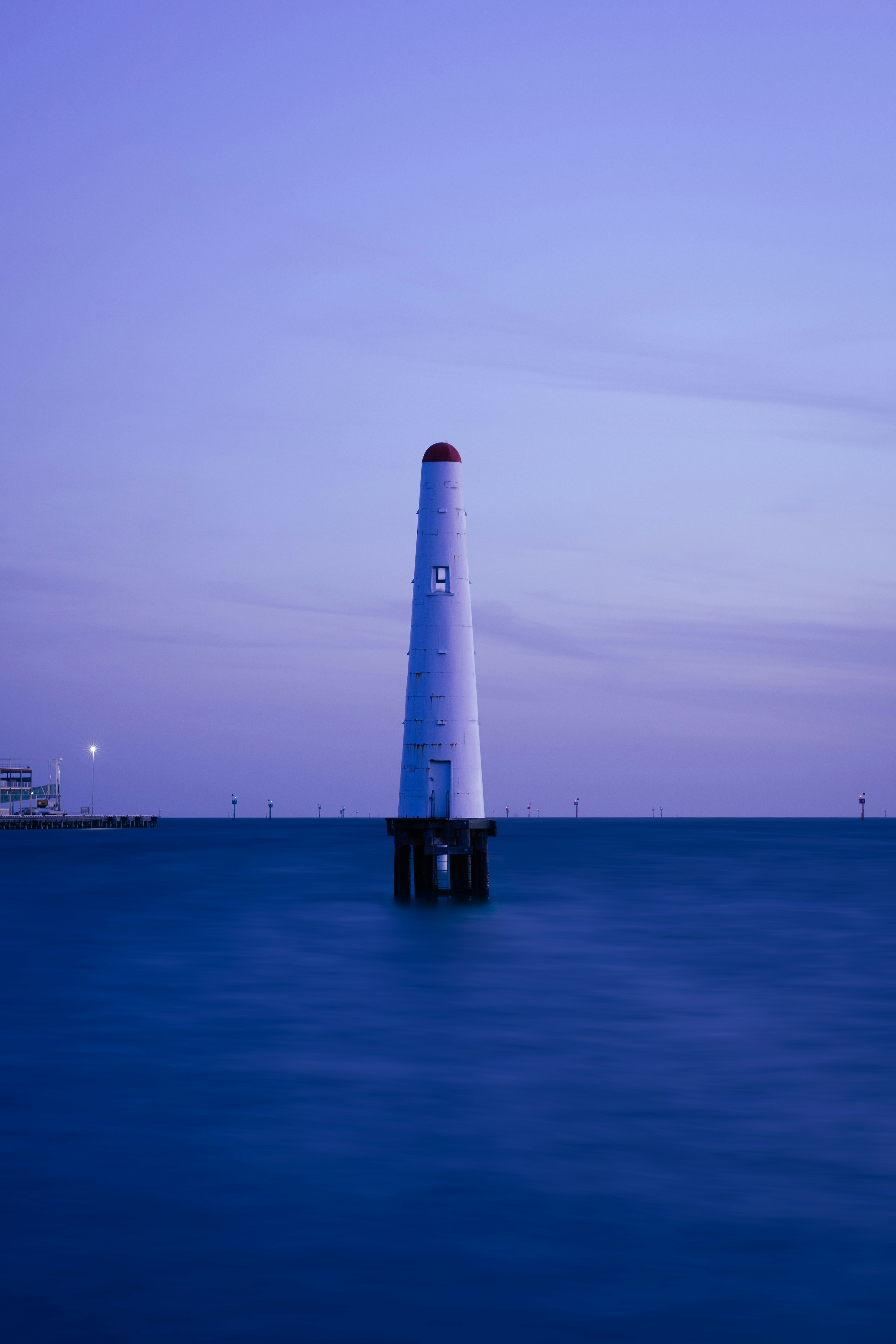 Blue Hour Beacon: A Lone Lighthouse Rising Over a Glassy Sea