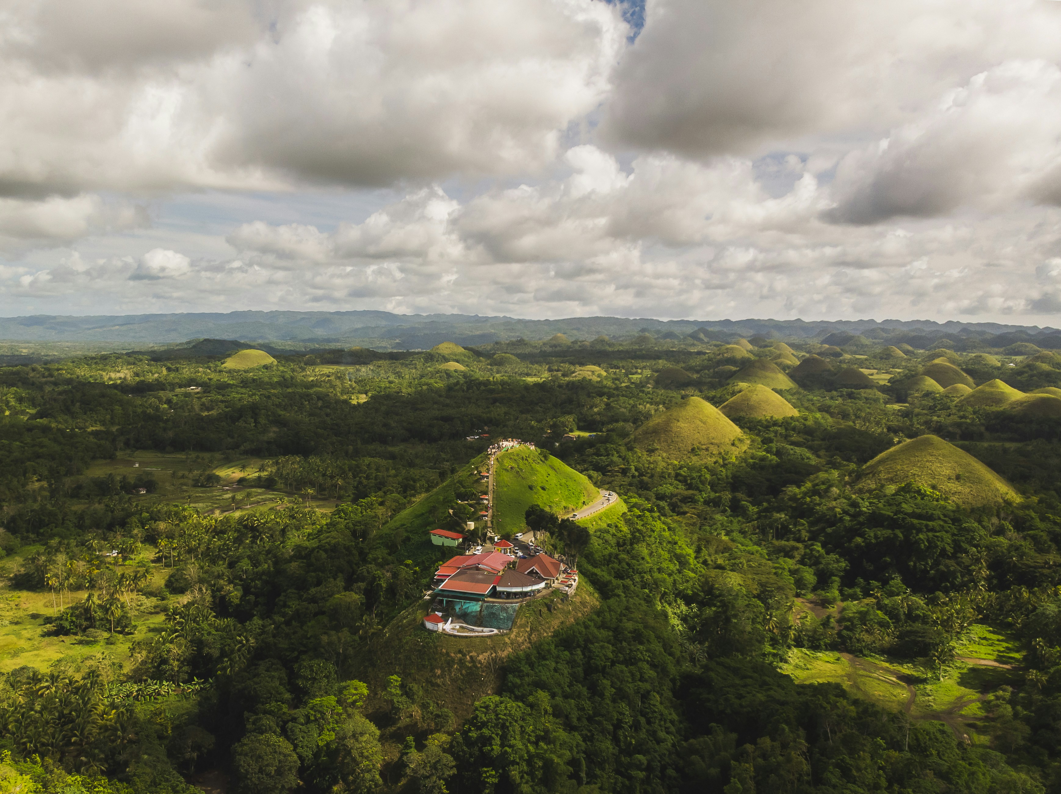 aerial view of green trees under cloudy sky during daytime