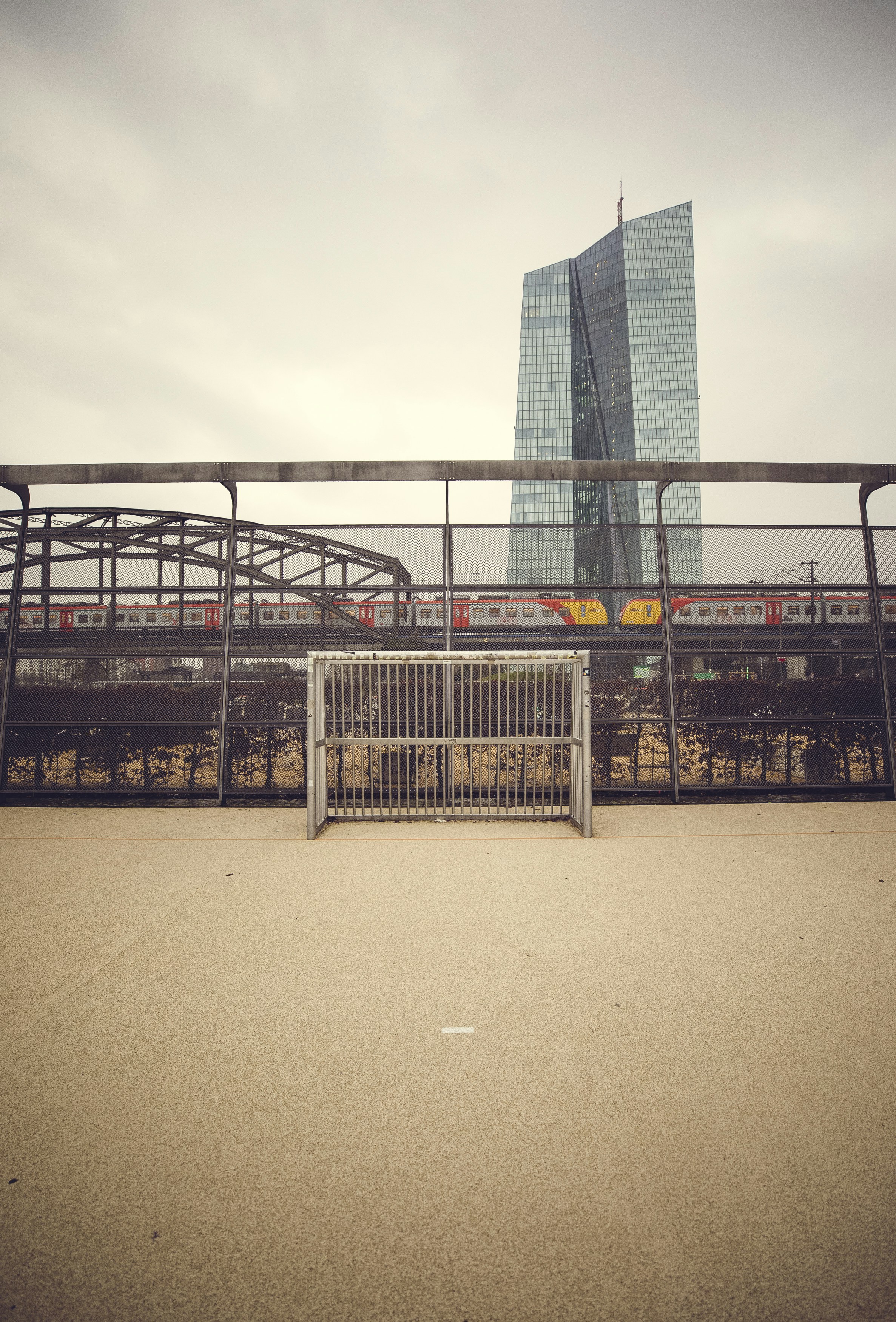 Urban Quiet at the Edge: A Bench, Rails, and a Skyward Glass Tower