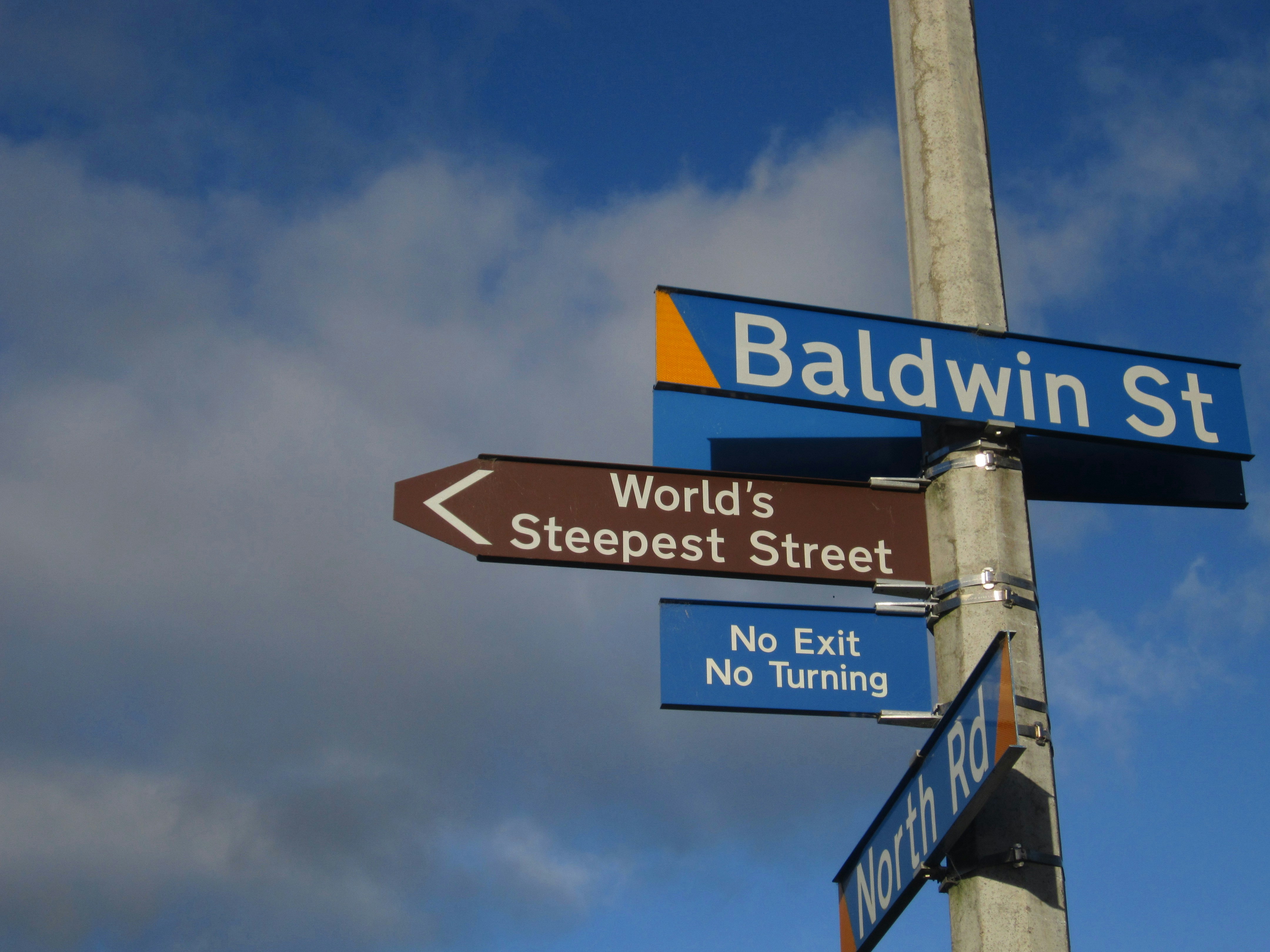 Blue and white street sign under blue sky during daytime photo – Free ...