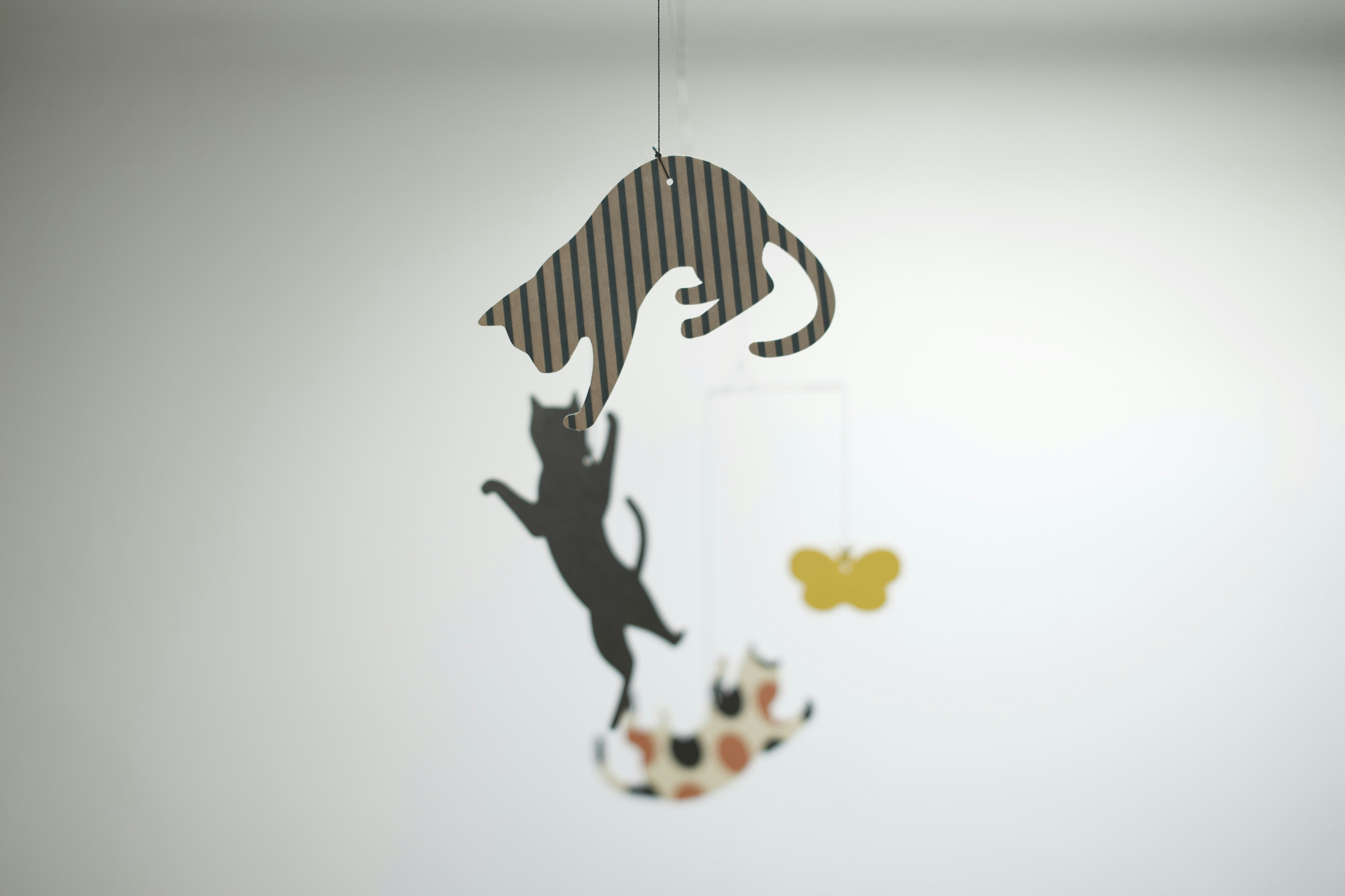 Hanging Whimsy: Cutout Cats and Butterfly in Soft Focus