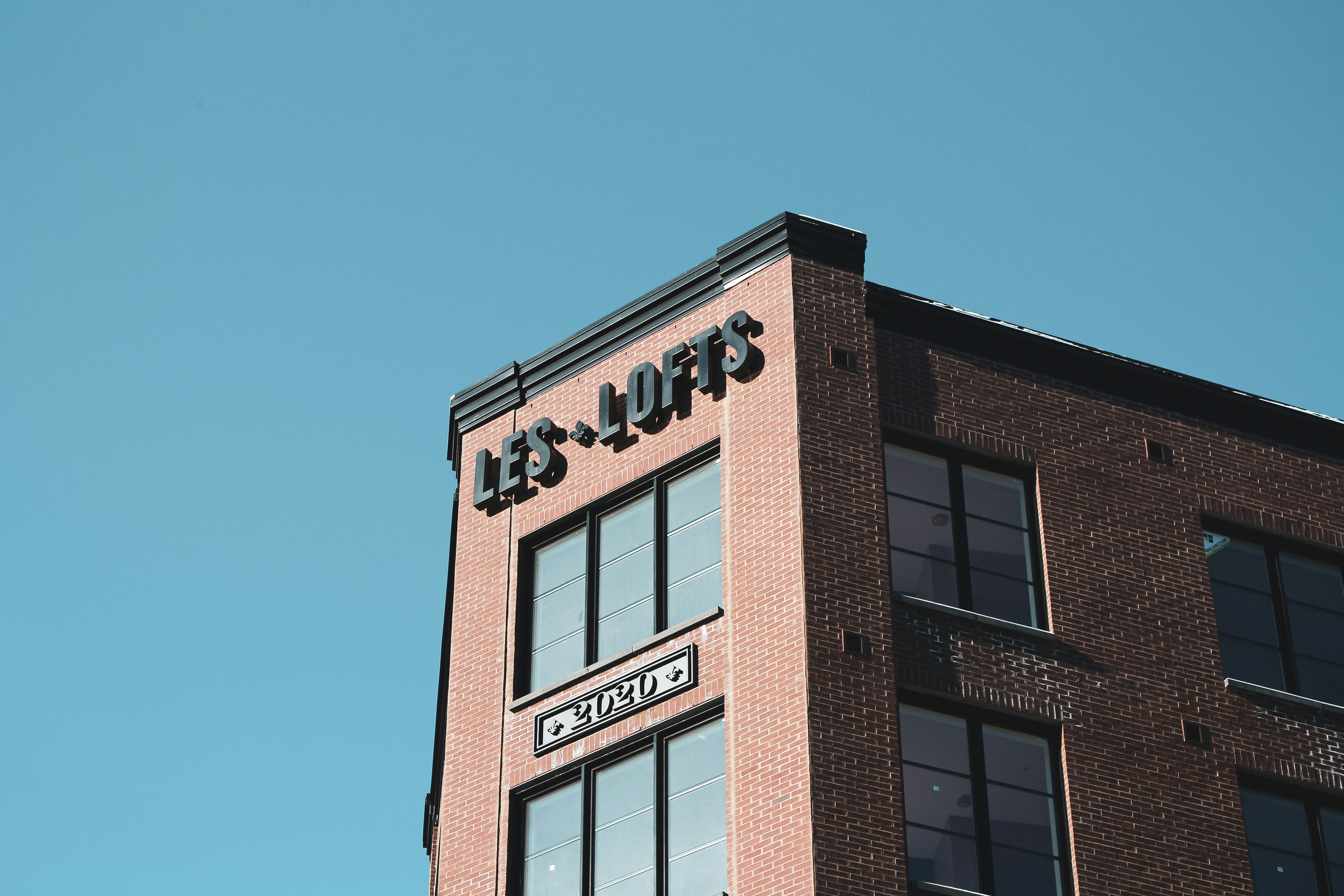 Les Loups Above the Brick Edge: Signage Reaching Toward a Clear Sky