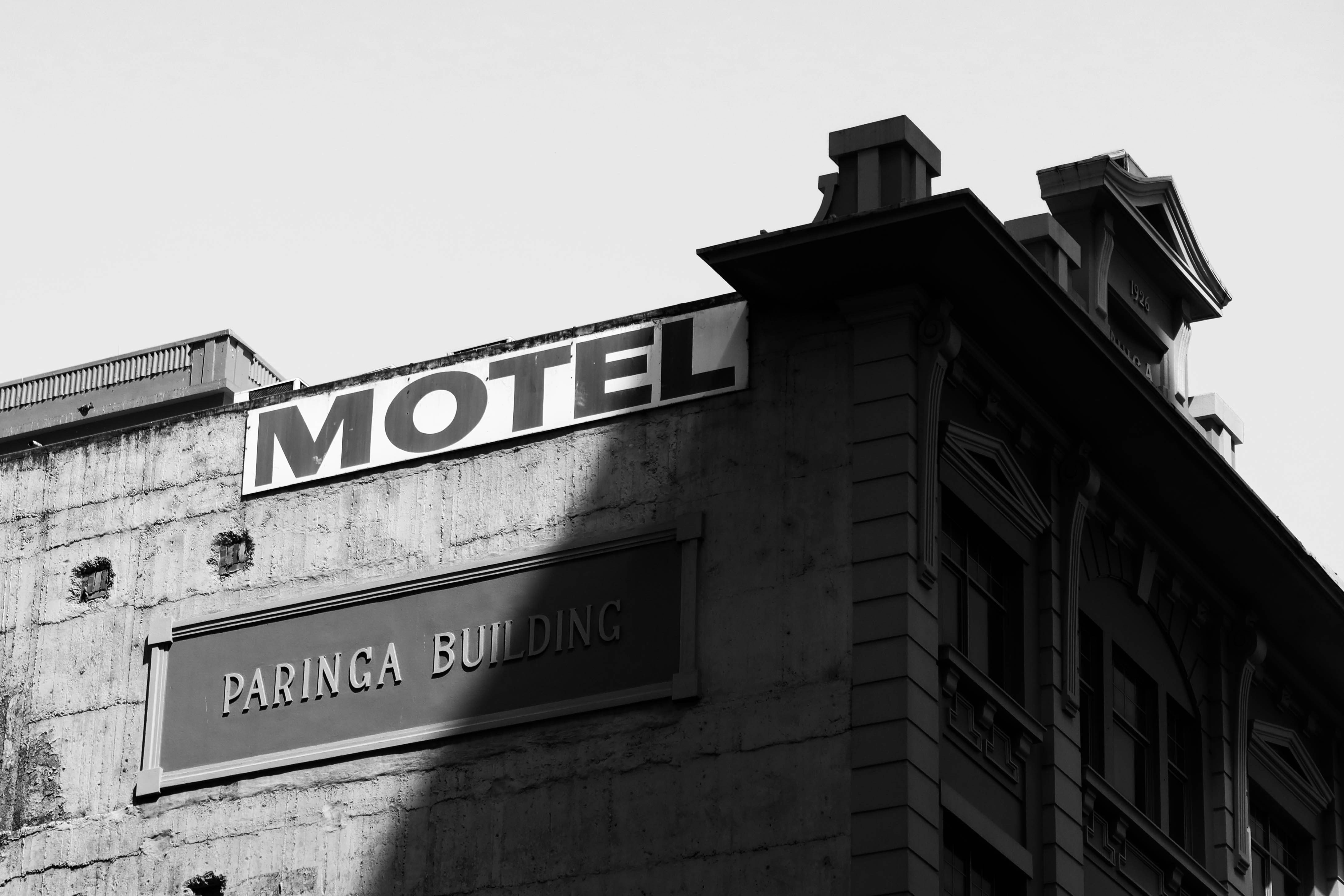 Signage at Dusk: A Crumbling Motel Facade in Monochrome
