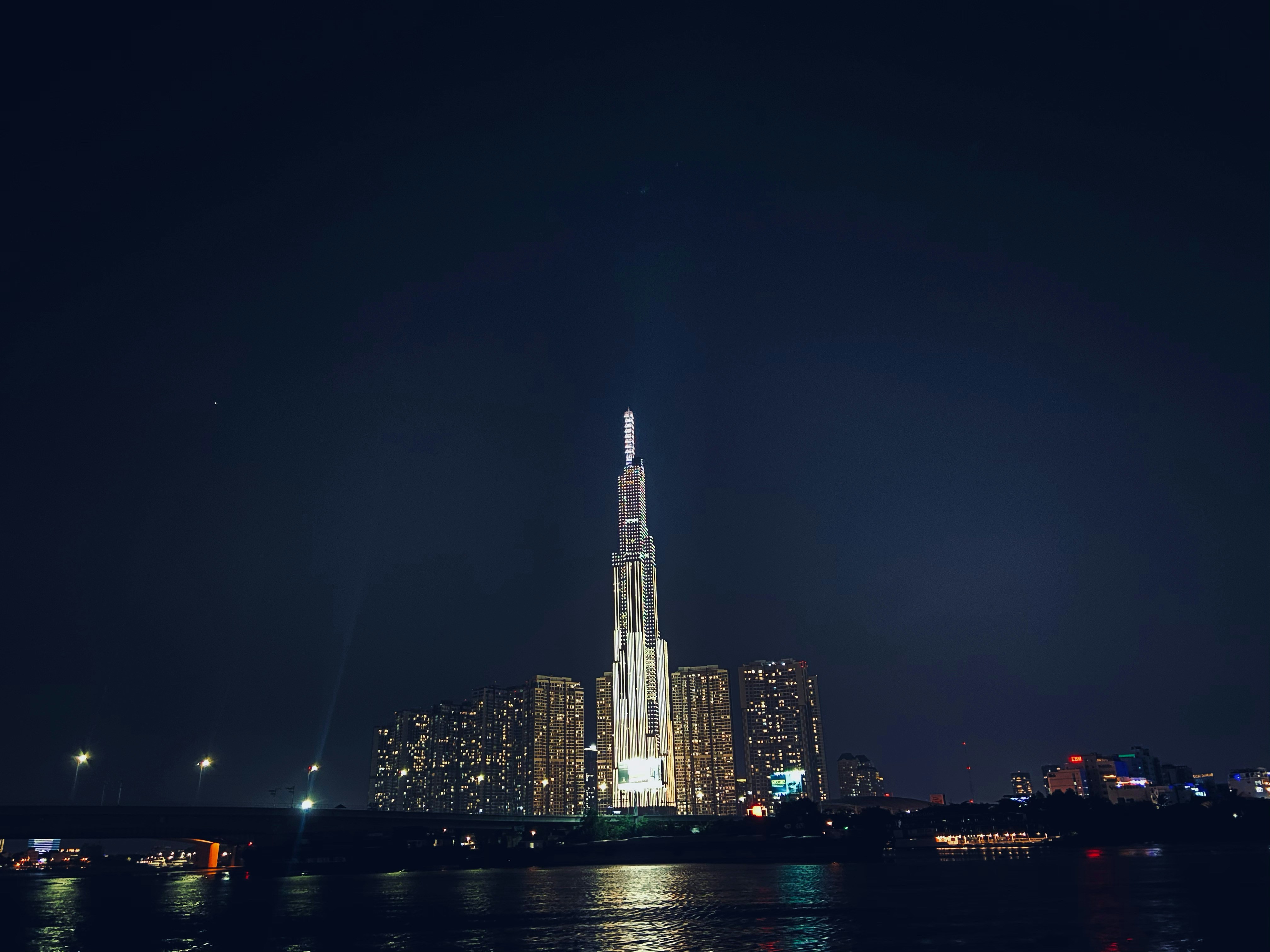 Nighttime Beacon over Velvet Waterfront: The Central Spire Dominates the Skyline