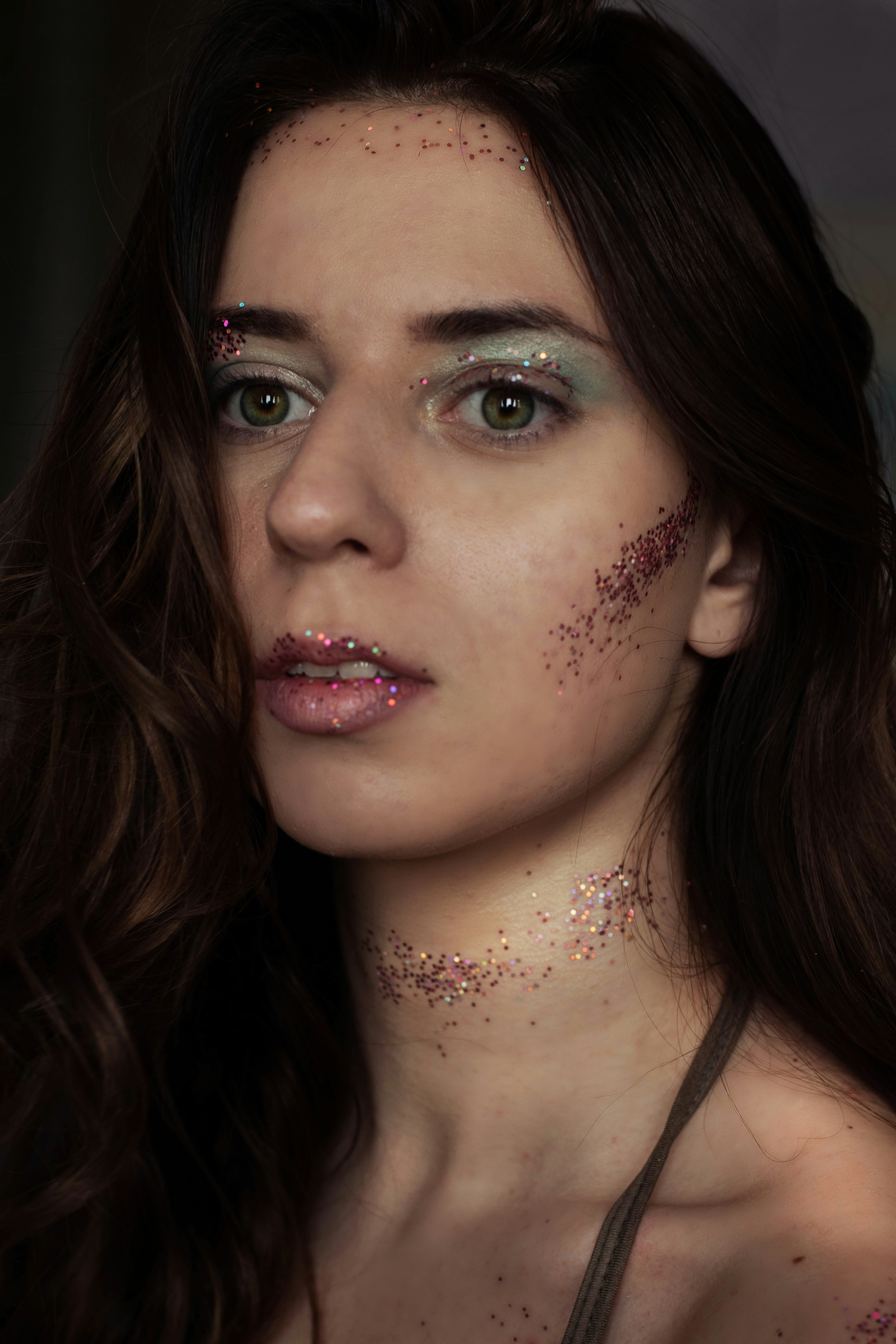 Glittered Portrait: Close-up of a Young Woman with Neon Glitter on Face