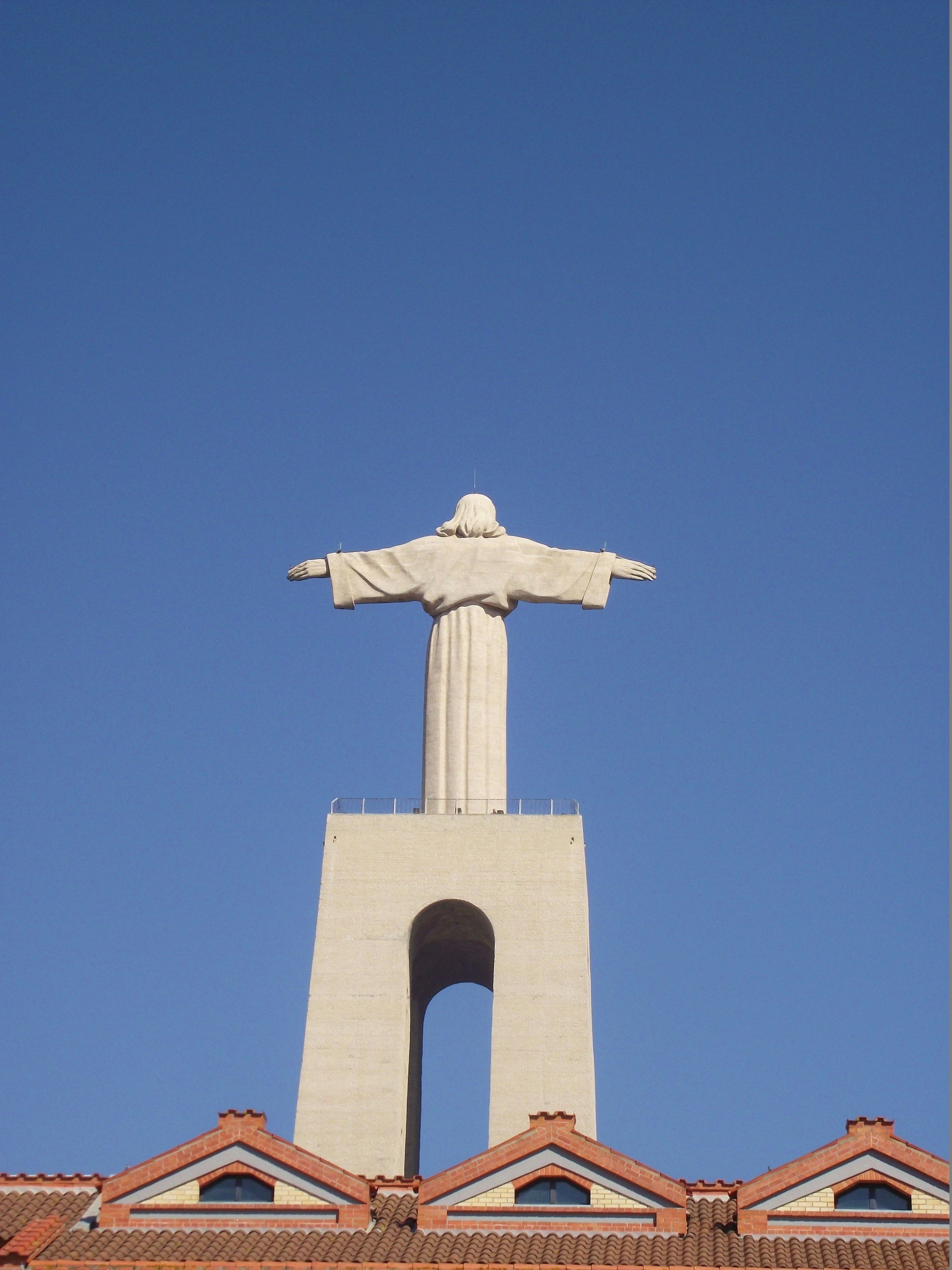 Huge Christ statue „Christo Rei“ in Almada, near Lisbon, Portugal. It towers over the river Tejo. Height: 104 meters, built in 1959. Visitors can take a lift to the viewing platform high above. Southwest Europe.