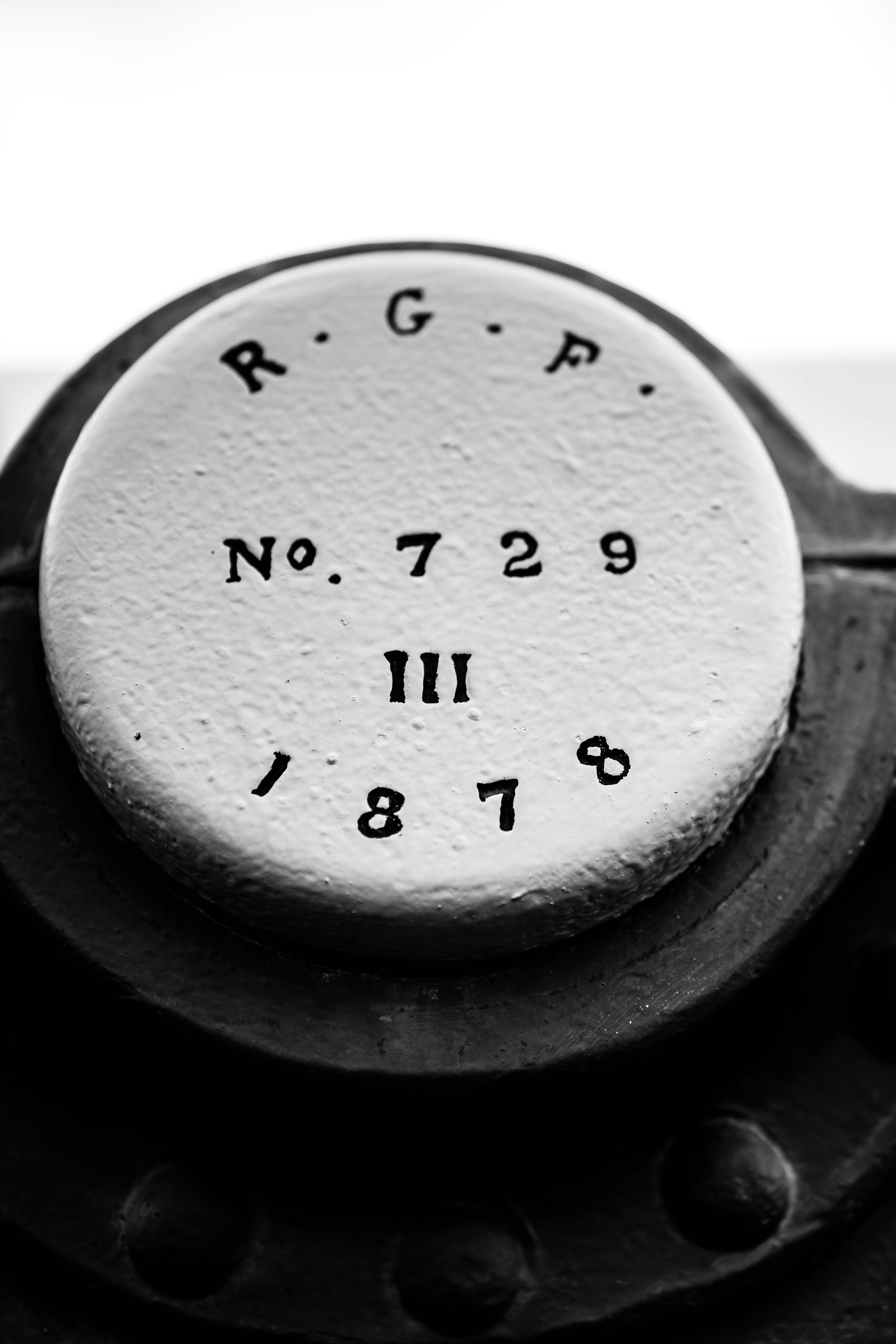 Grayscale close-up of a vintage camera dial revealing tactile typography