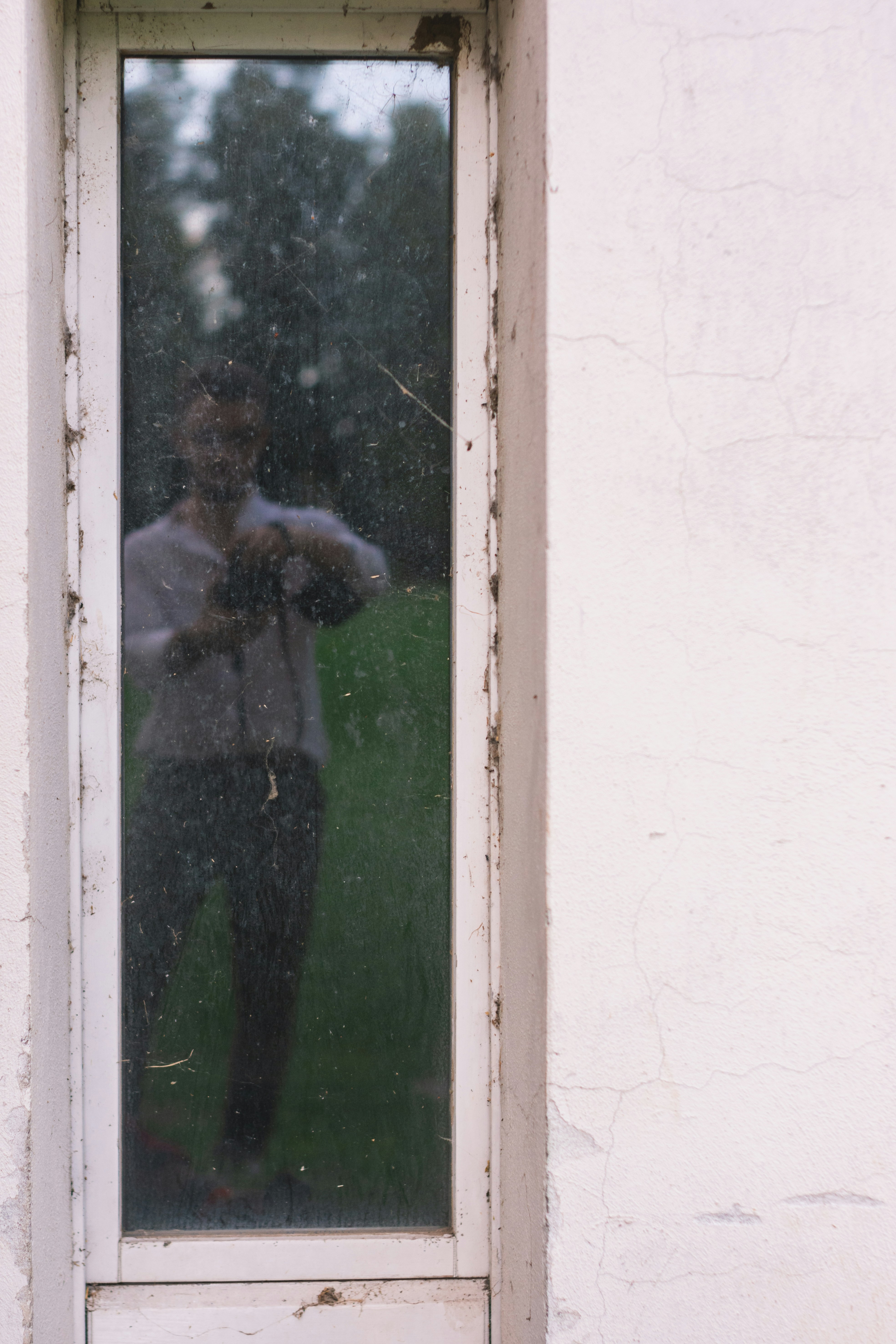 Pane Portrait: A Self-Reflective Moment in a Weathered Window