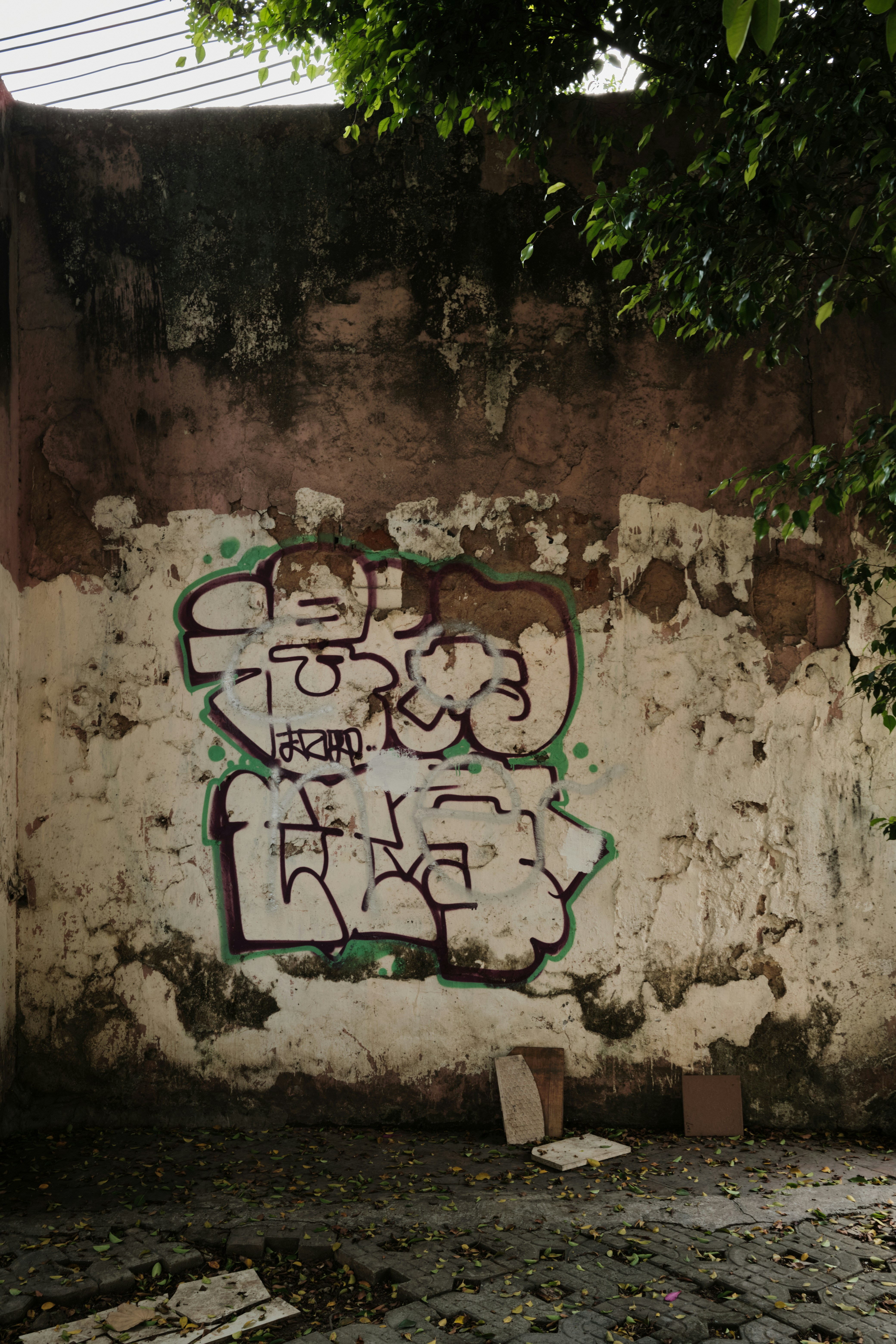 green and white graffiti on brown concrete wall