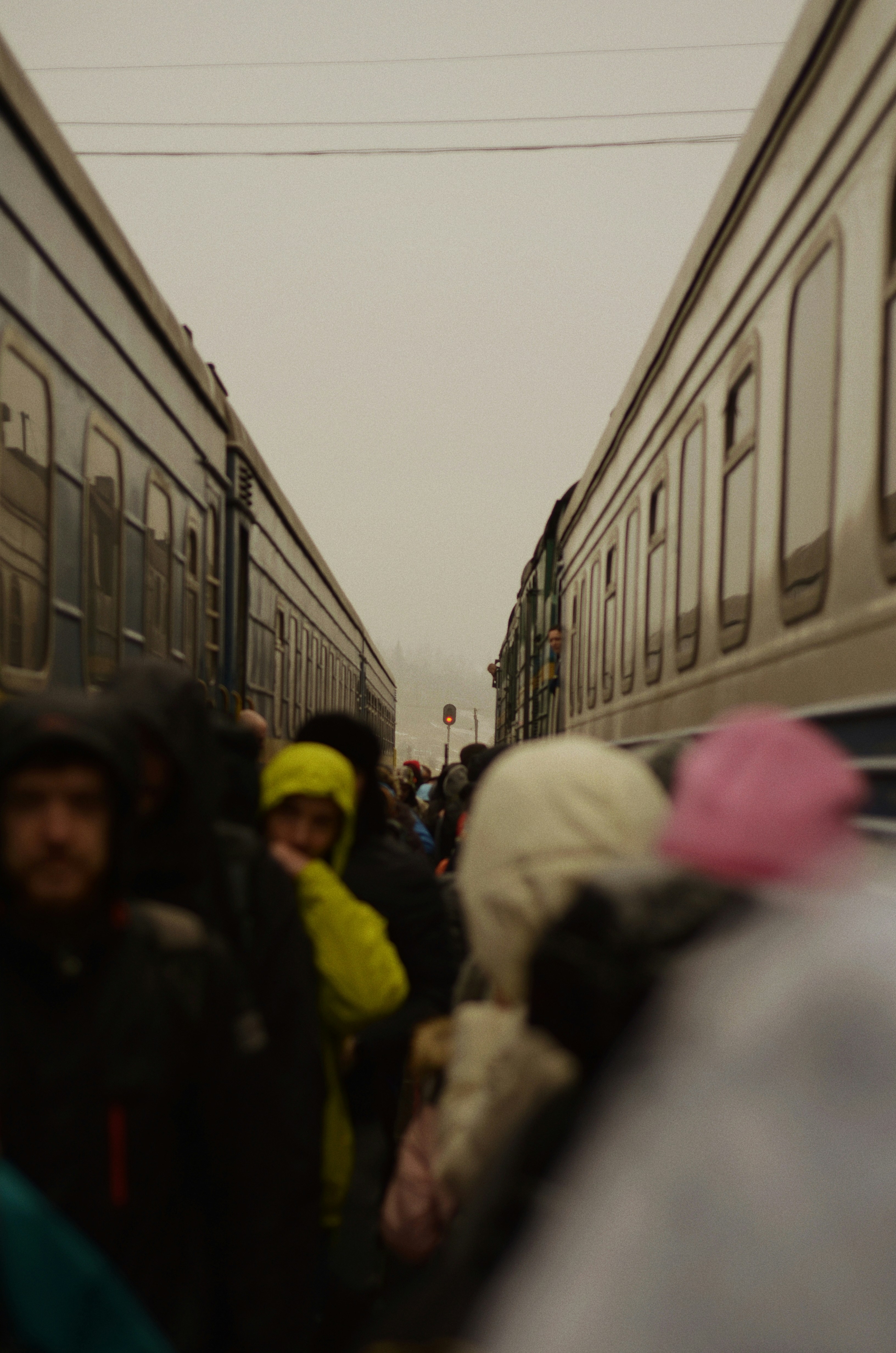 Midday Convergence: Train Platform Crowd Framed by Distant Rails